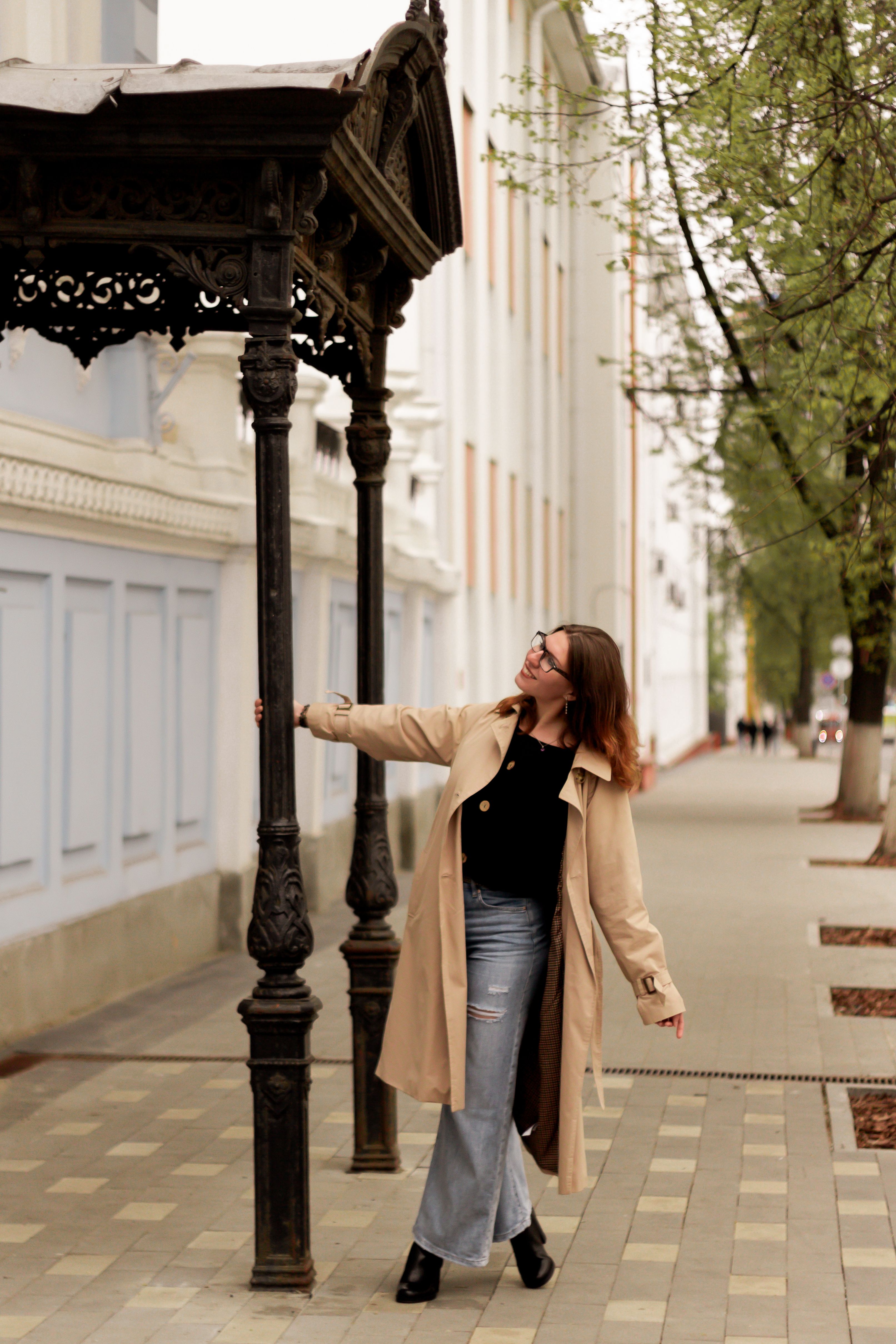 Woman Standing and Holding the Pole of a Street Sign · Free Stock Photo