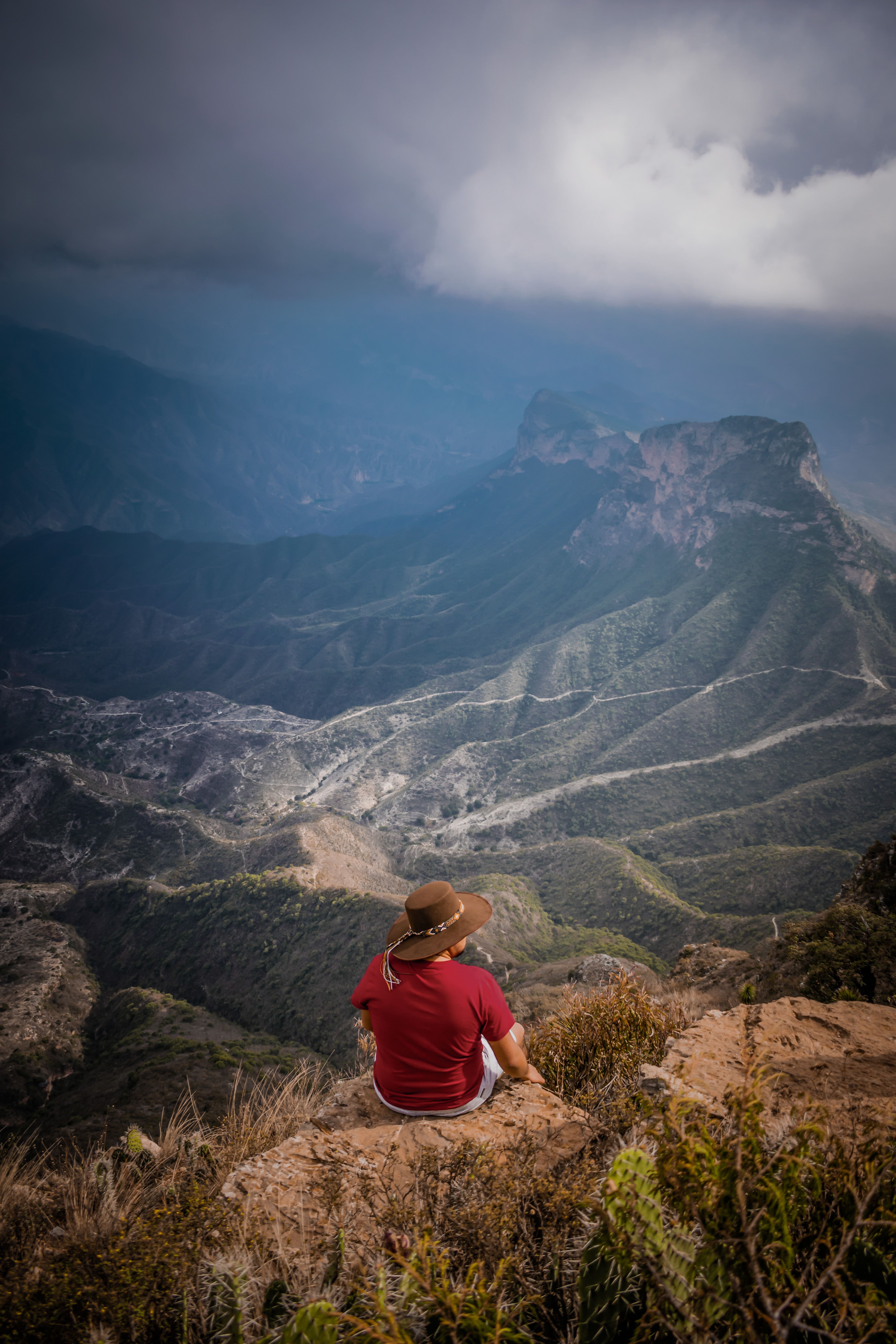 Back view of a Man in a Hat Looking at Rocky Landscape · Free Stock Photo