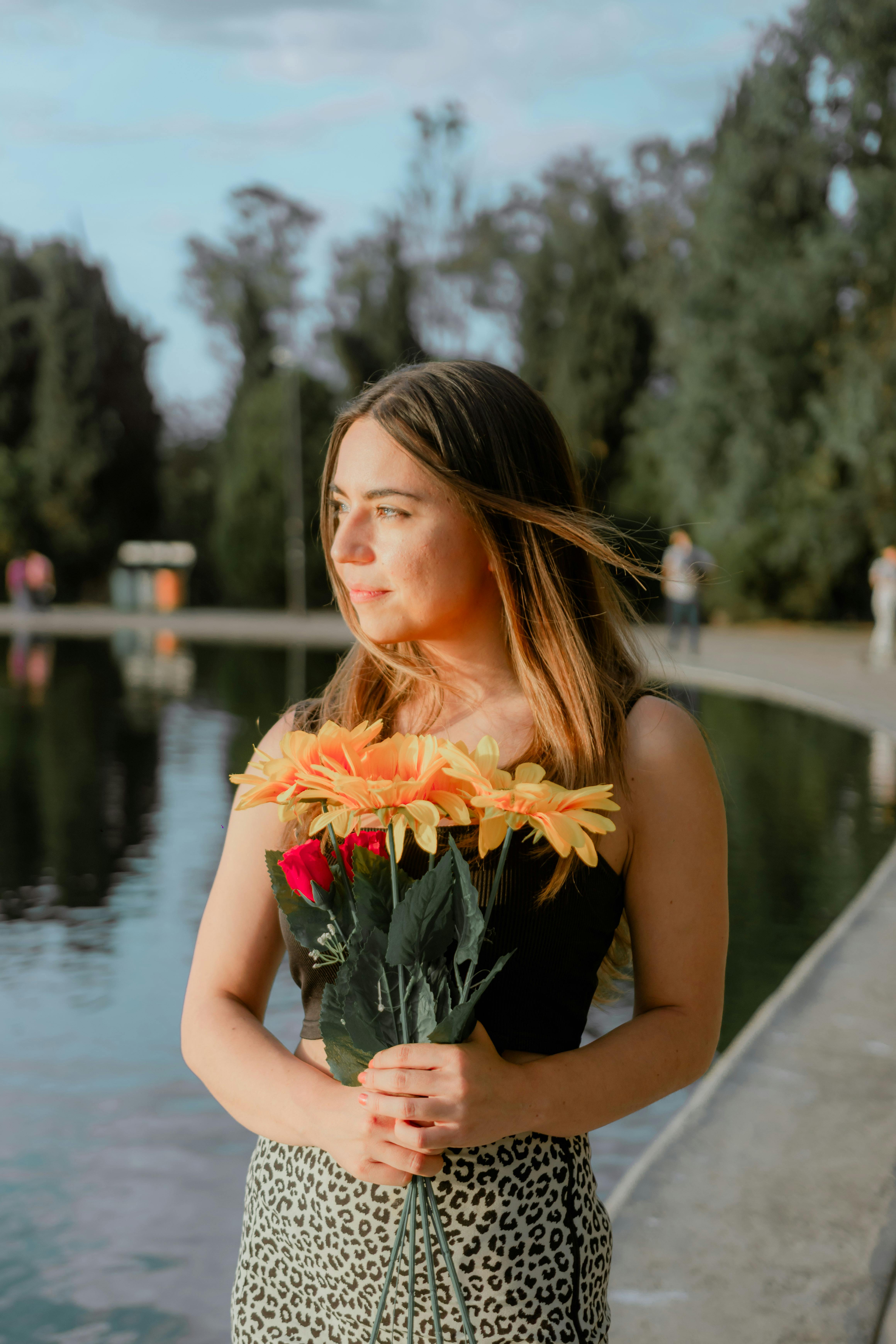 Woman in Black Tank Top Holding Bouquet of Flowers · Free Stock Photo