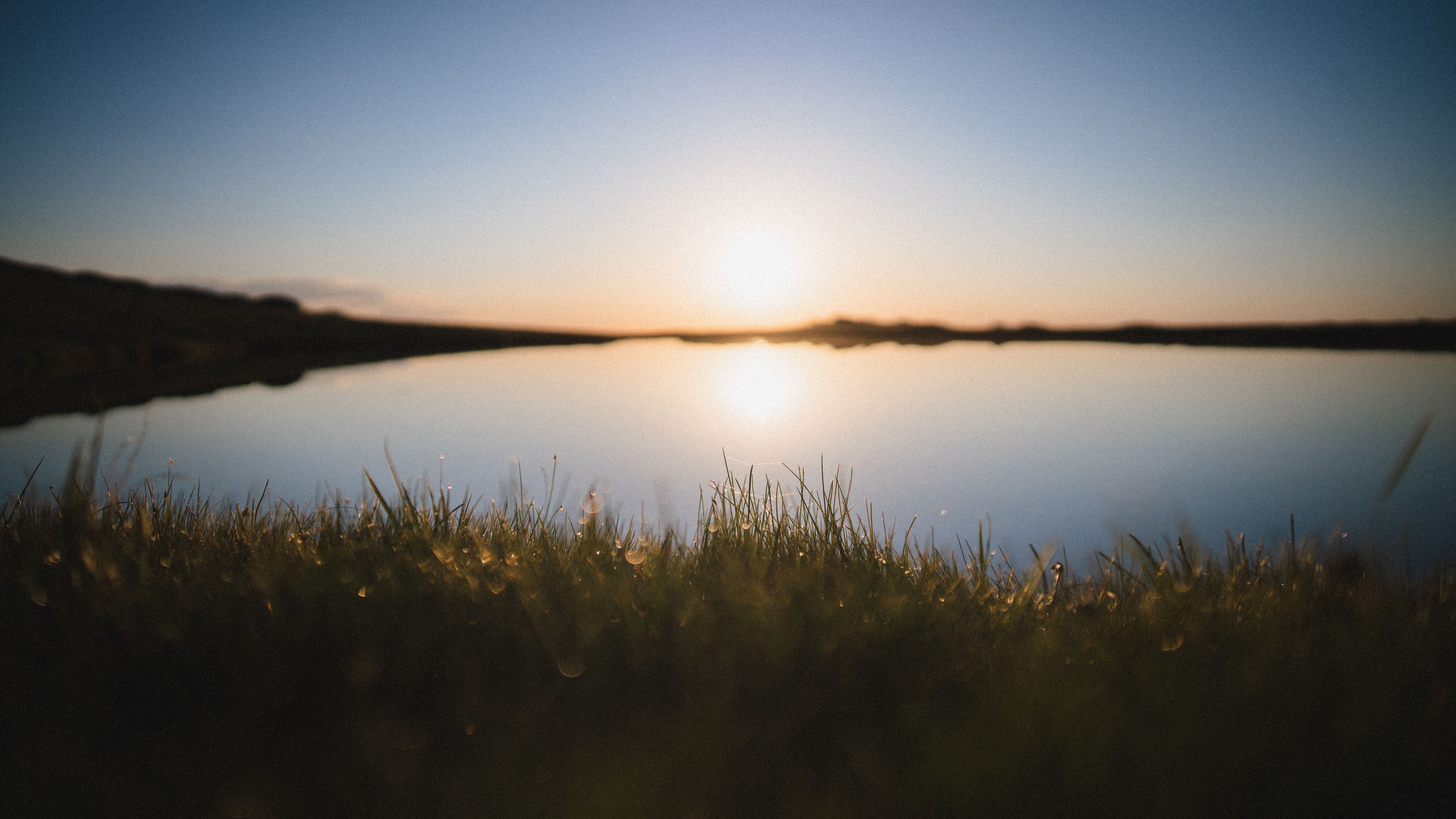 Green Grass Near Body of Water during Sunset · Free Stock Photo