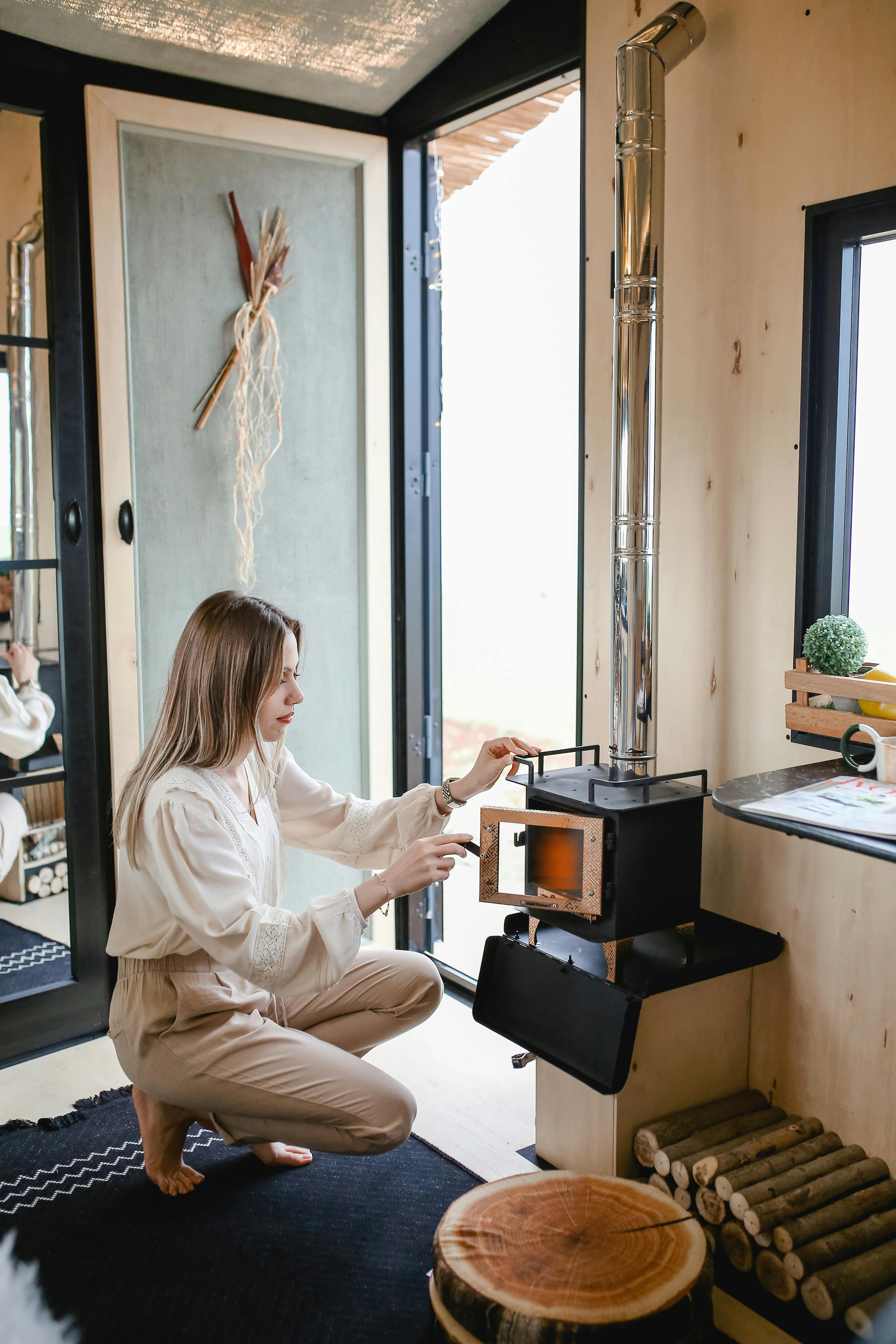 Woman Lighting a Fire in the Fireplace in a Tiny House on Wheels · Free ...