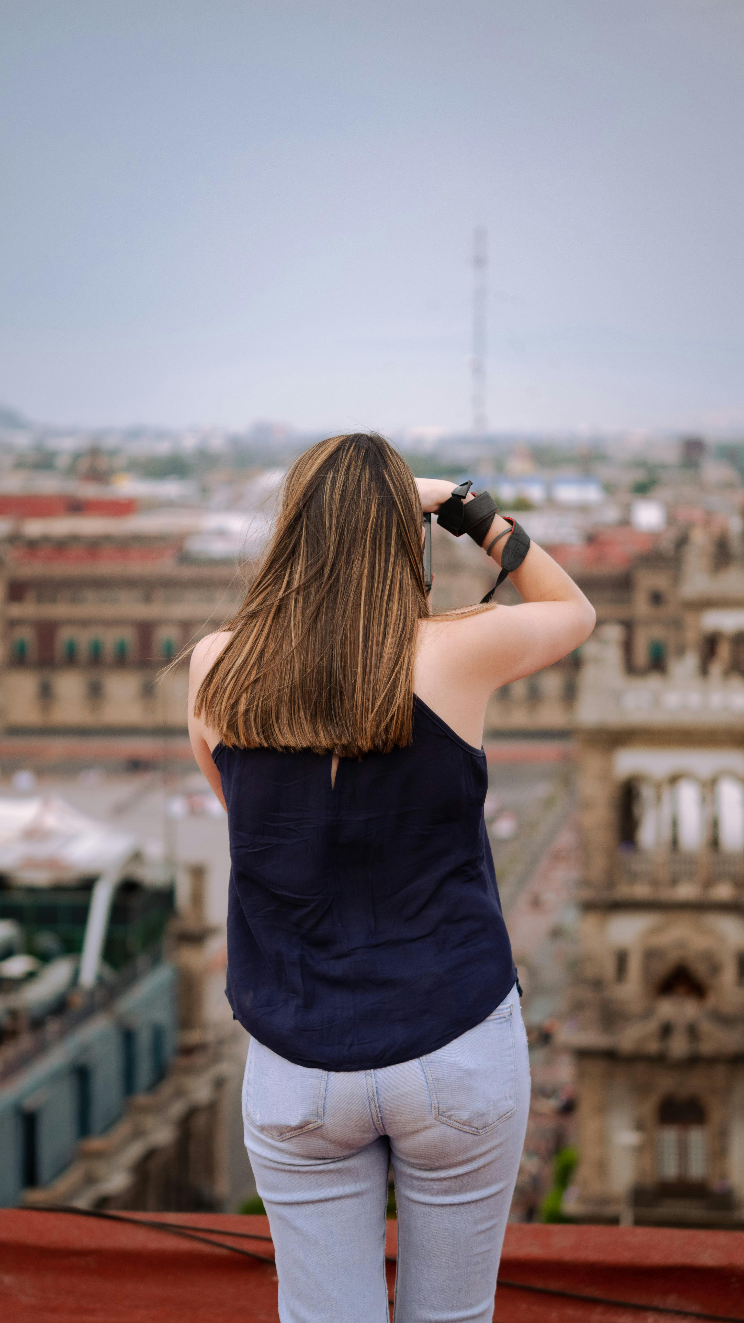 Woman Standing on Roof above City Streets · Free Stock Photo