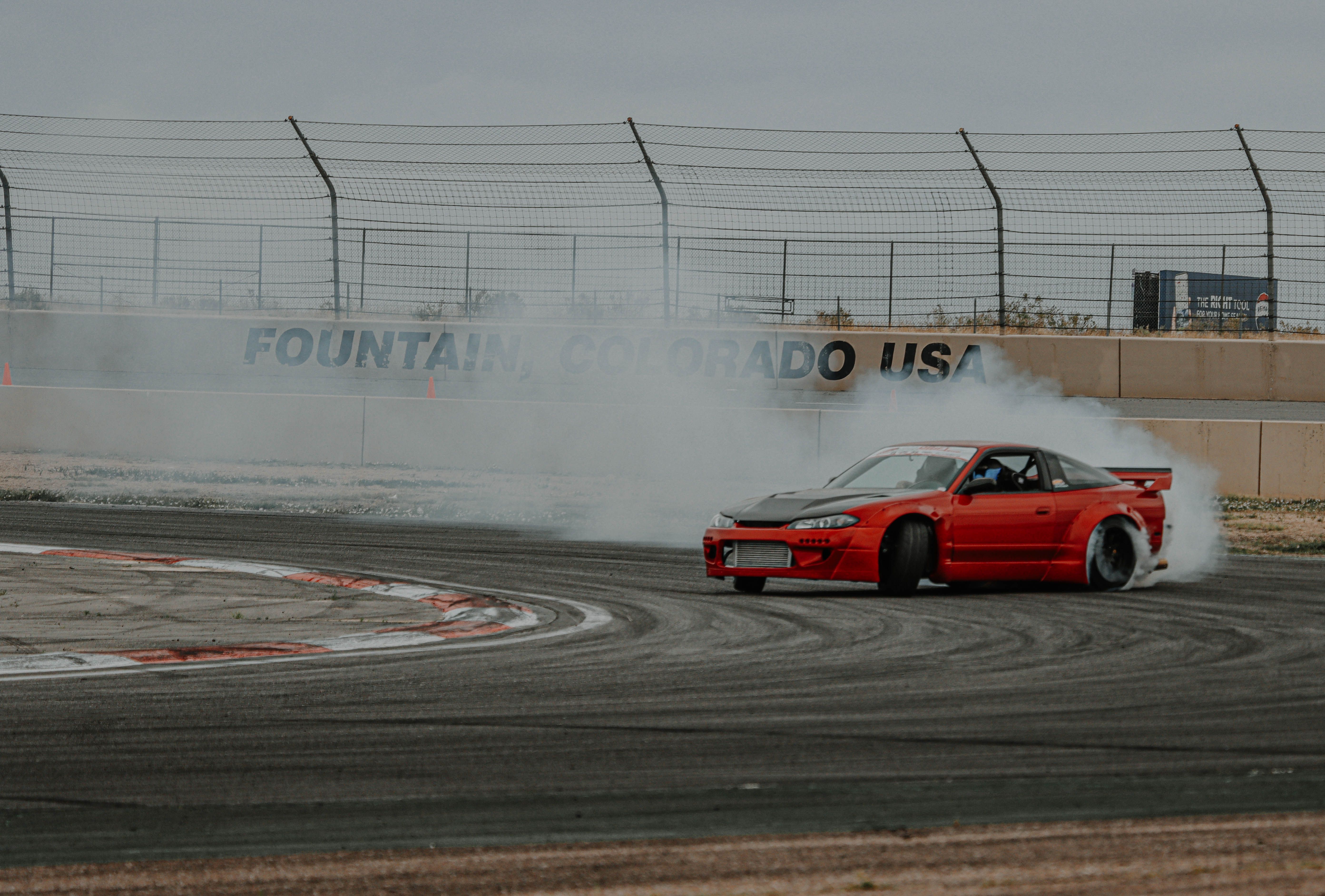 Action Shot of Red Racecar Drifting in Fountain · Free Stock Photo