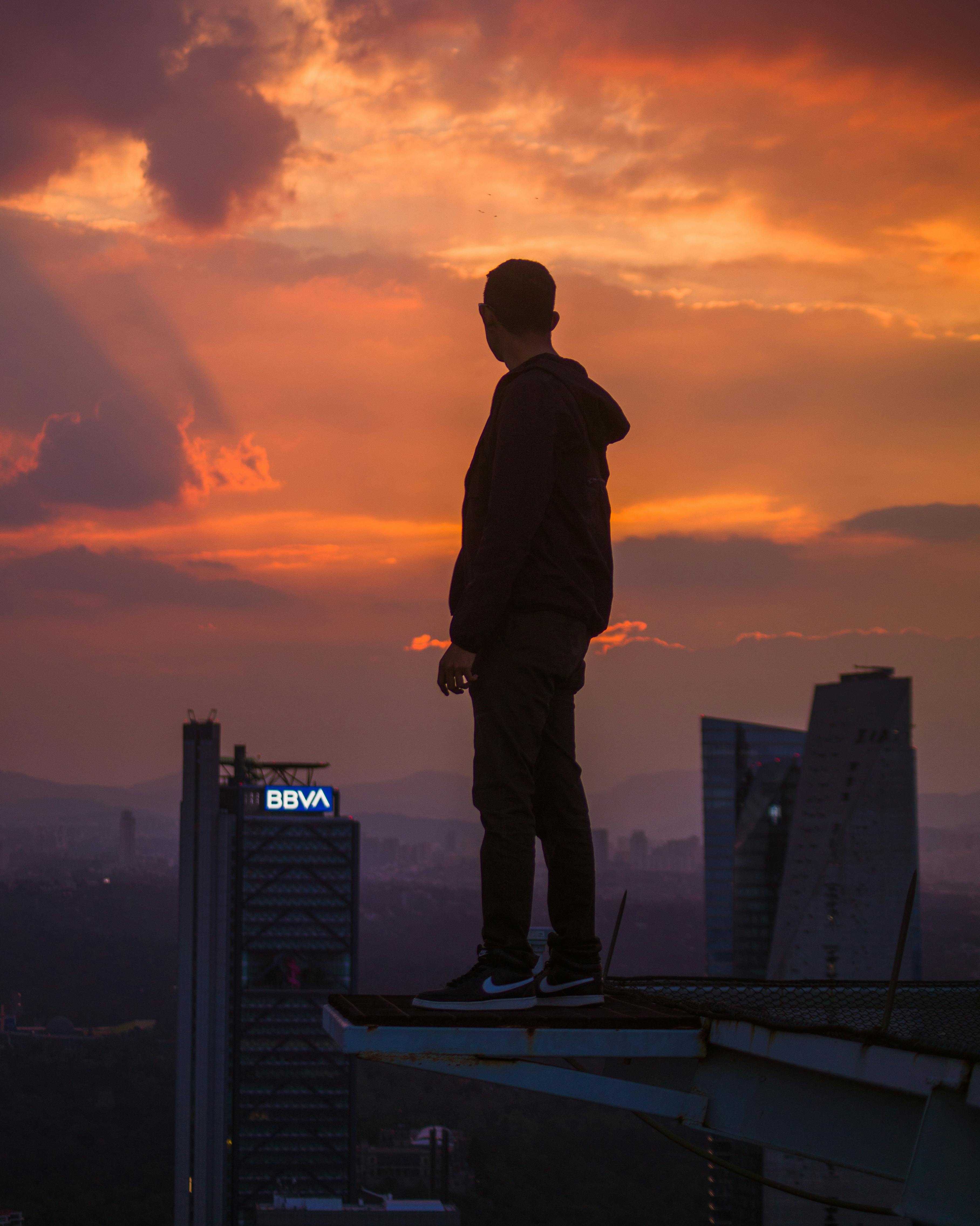 Man Standing on Rooftop at Sunset · Free Stock Photo