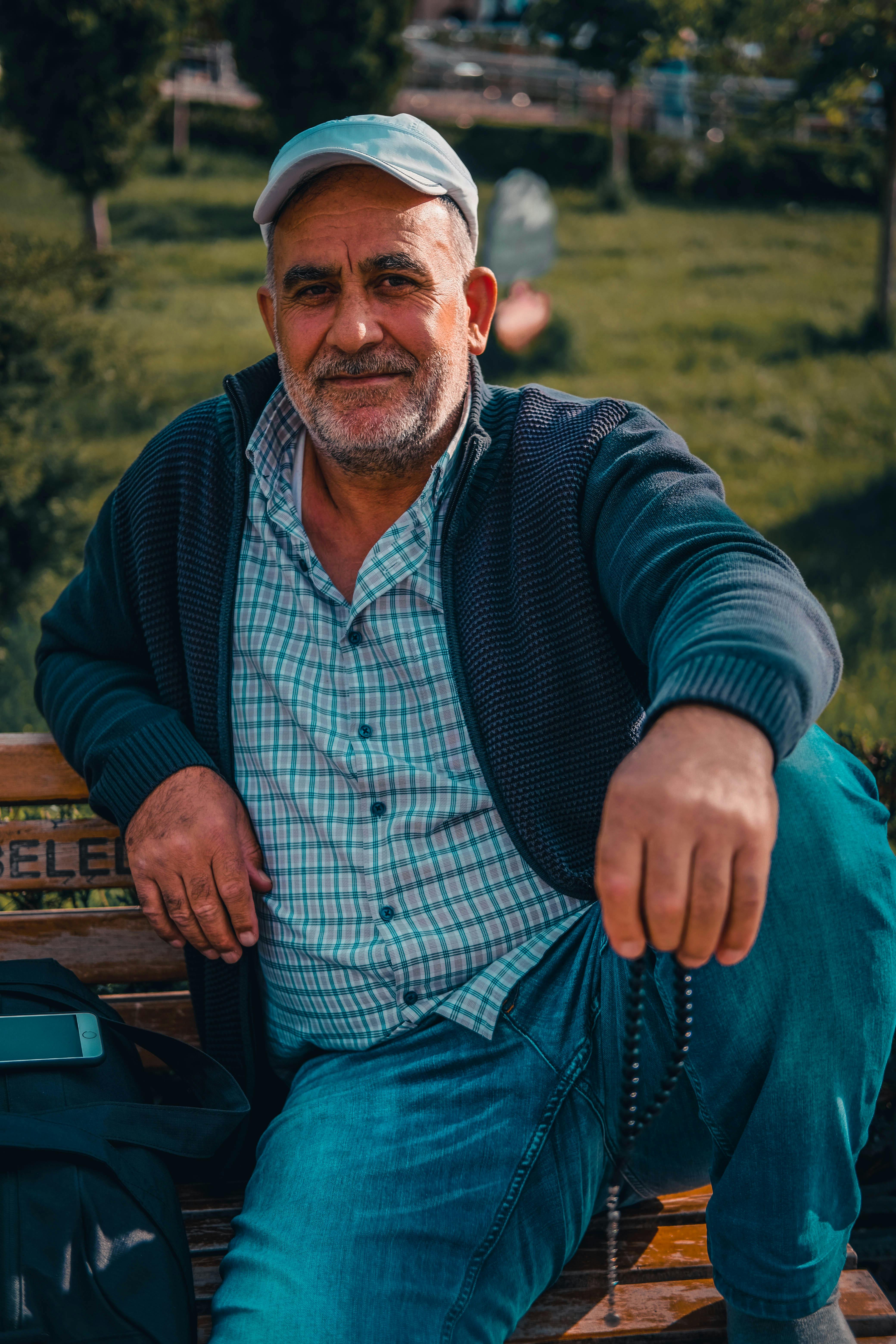 A Man Sitting on Wooden Bench · Free Stock Photo