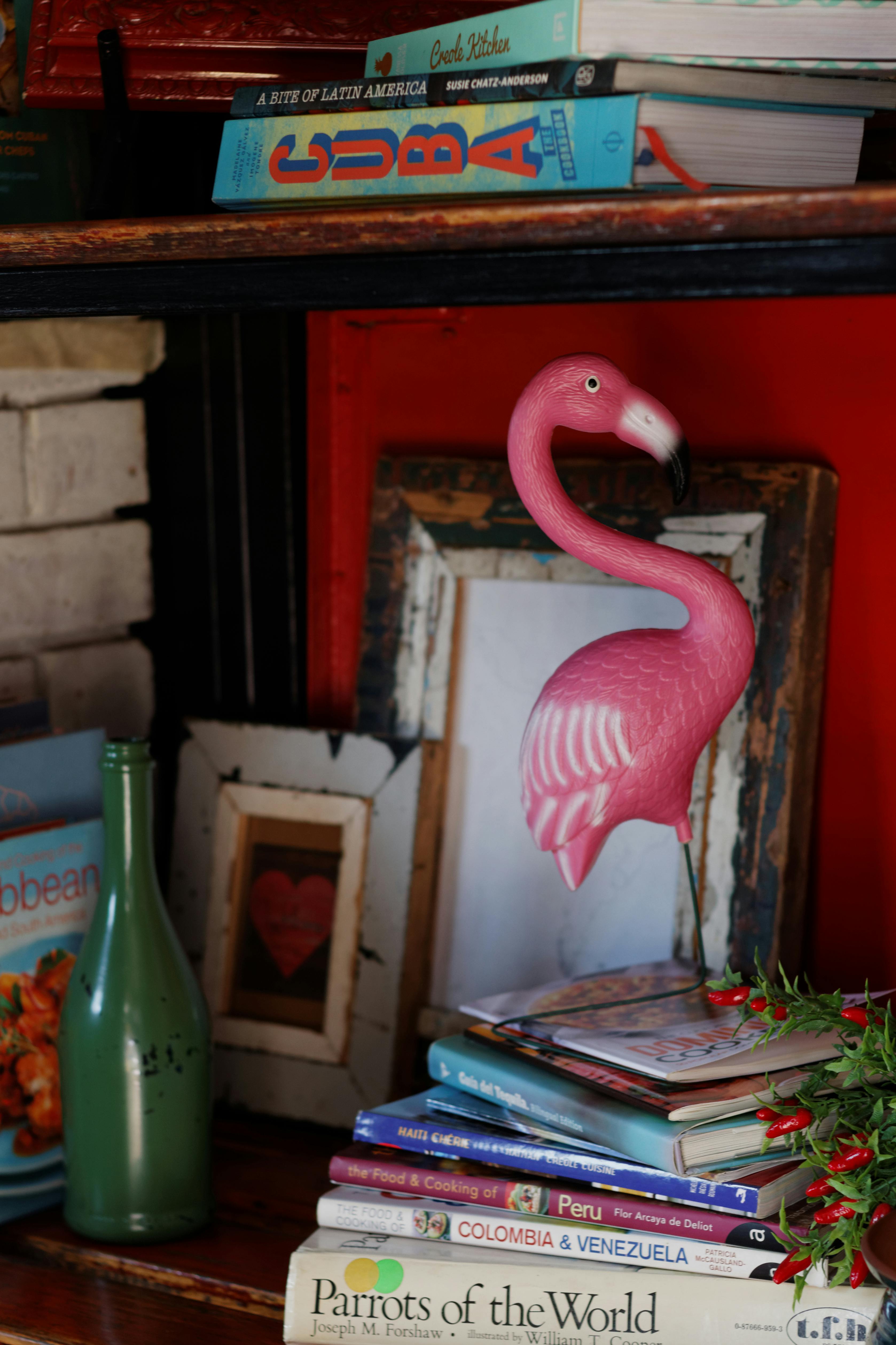 Pink Flamingo Figurine on a Stack of Books · Free Stock Photo