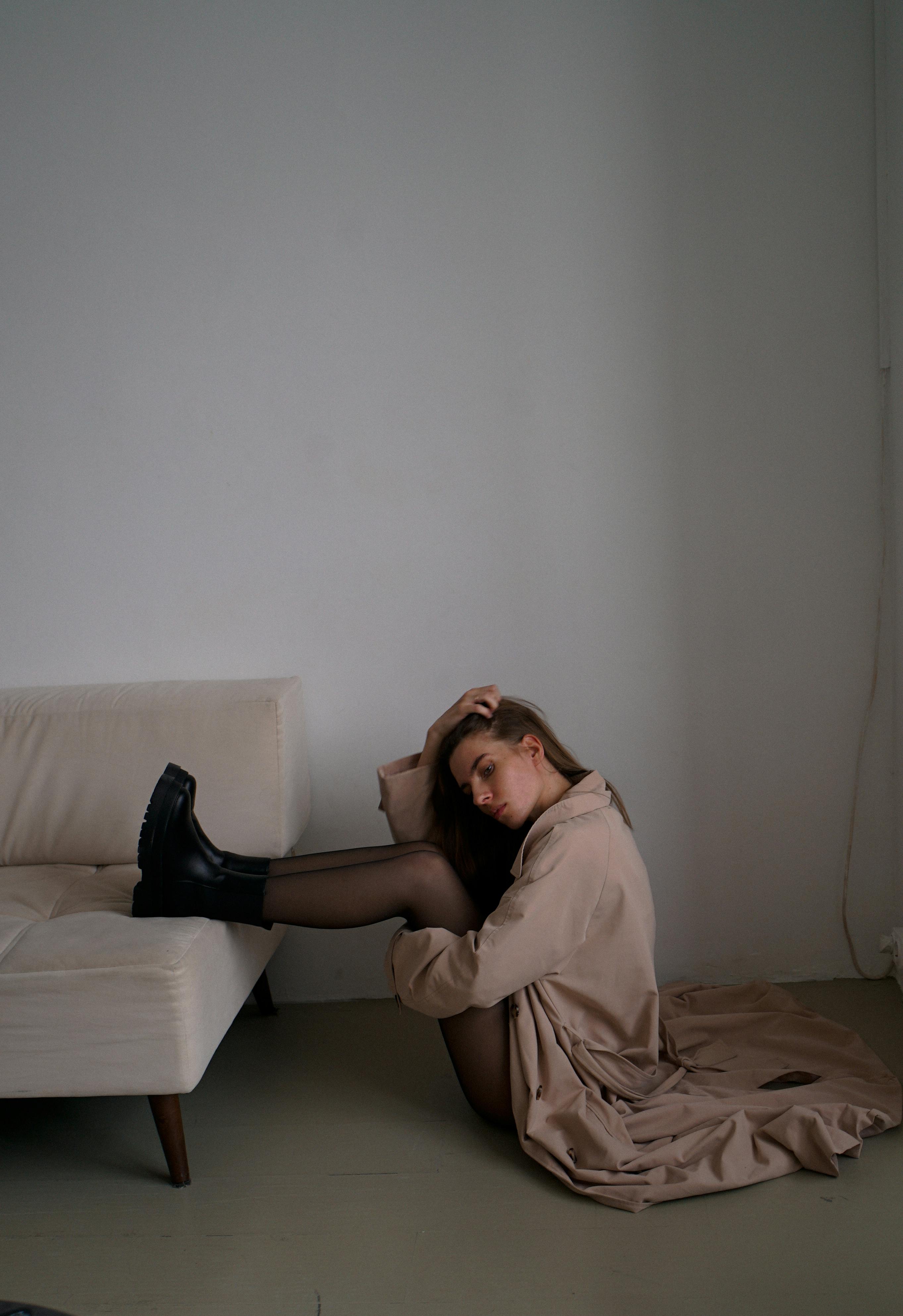 Woman Sitting on Ground with Legs on Sofa · Free Stock Photo