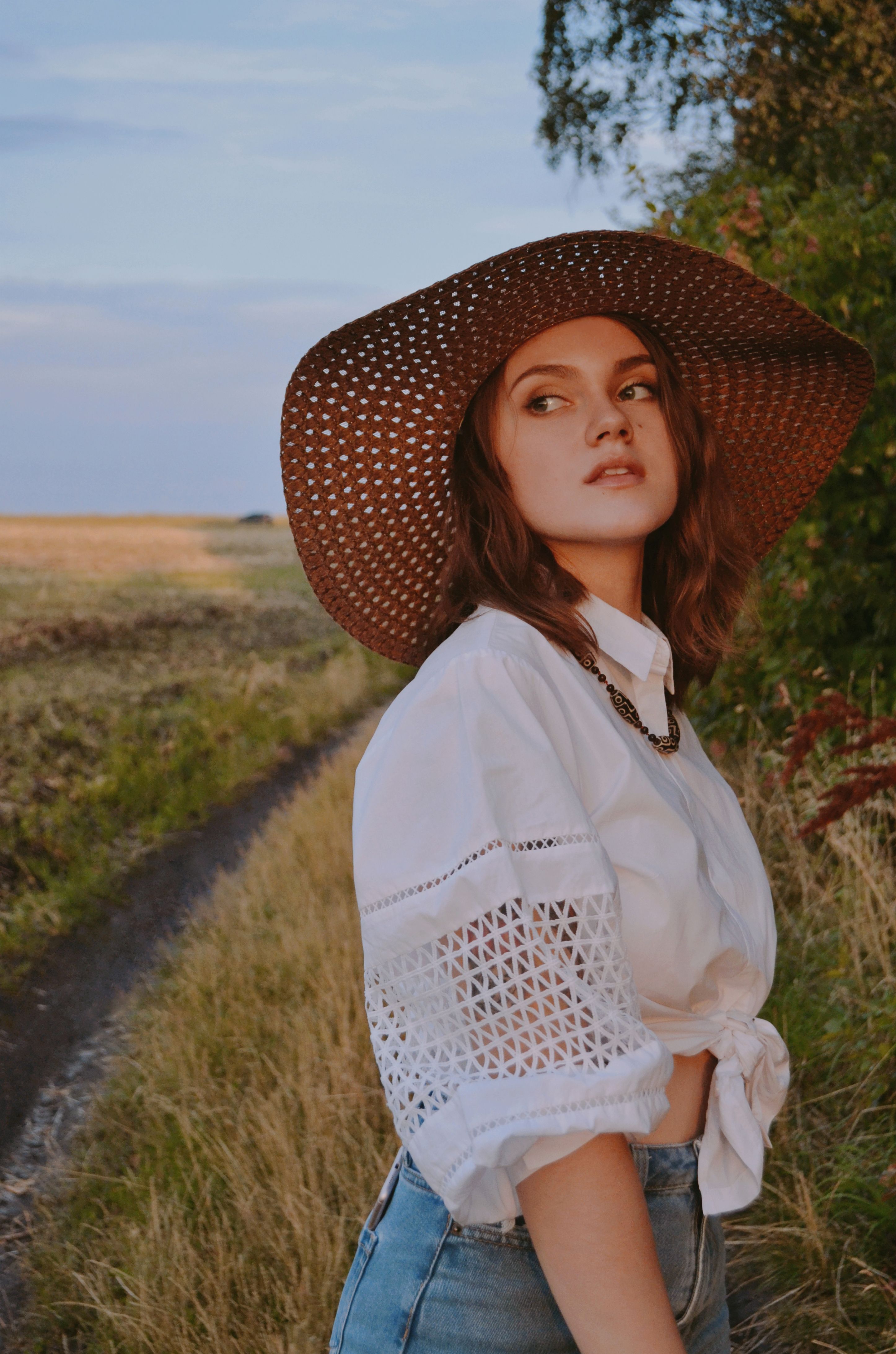 A Woman in a Sunhat Looking Over Her Shoulder · Free Stock Photo