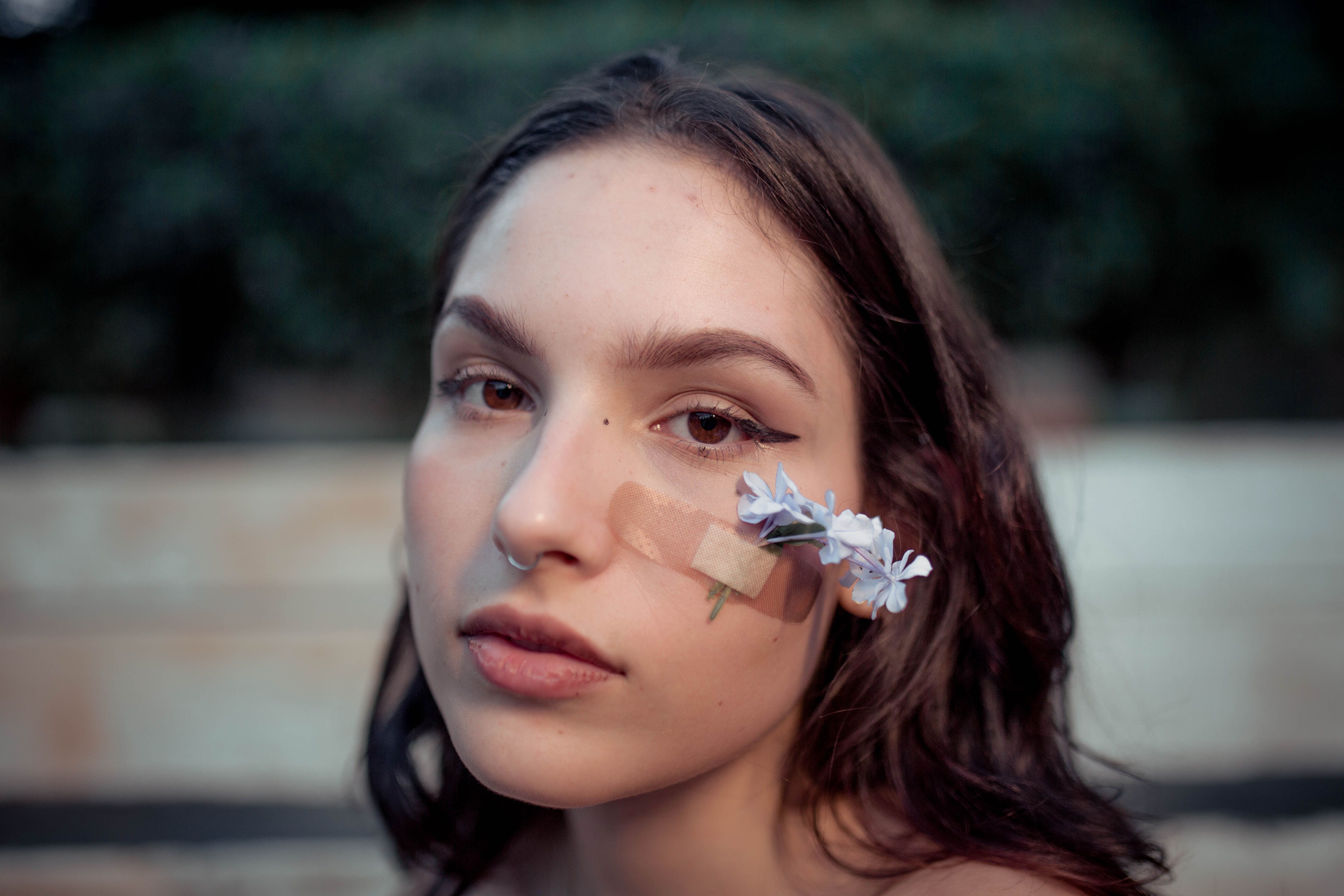 A Beautiful Woman with Band Aid and Flowers on Her Face · Free Stock Photo