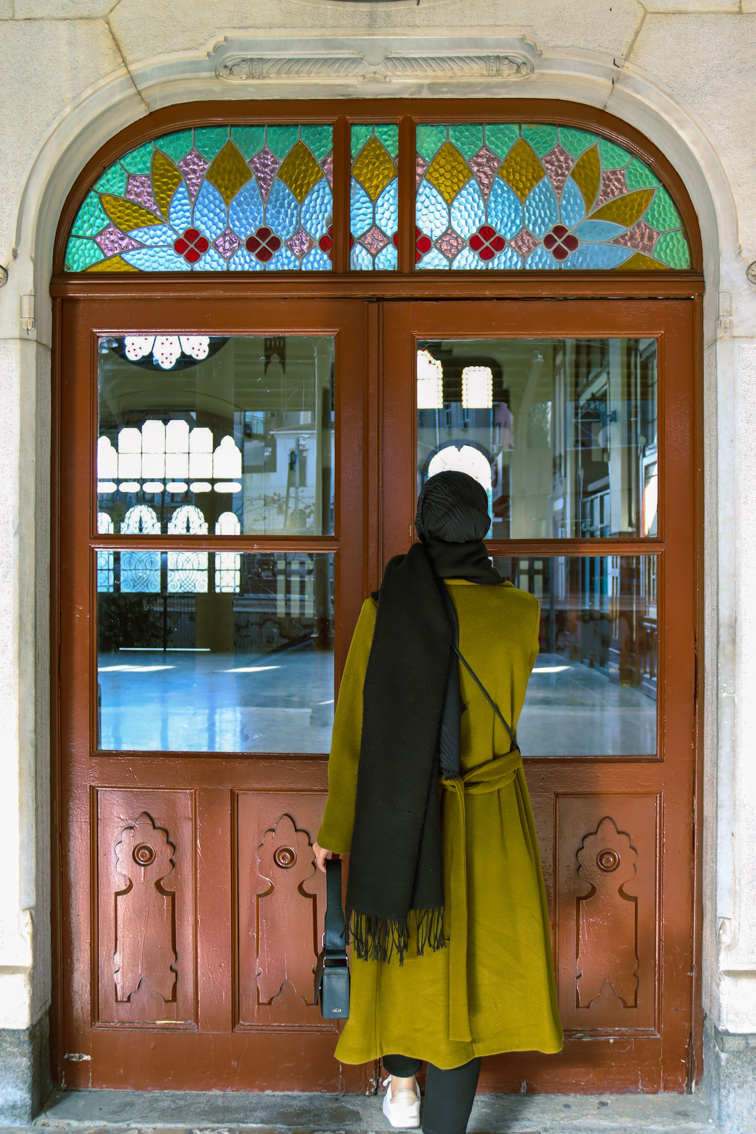 Back View of a Woman in Front of Door with Stained Glass · Free Stock Photo