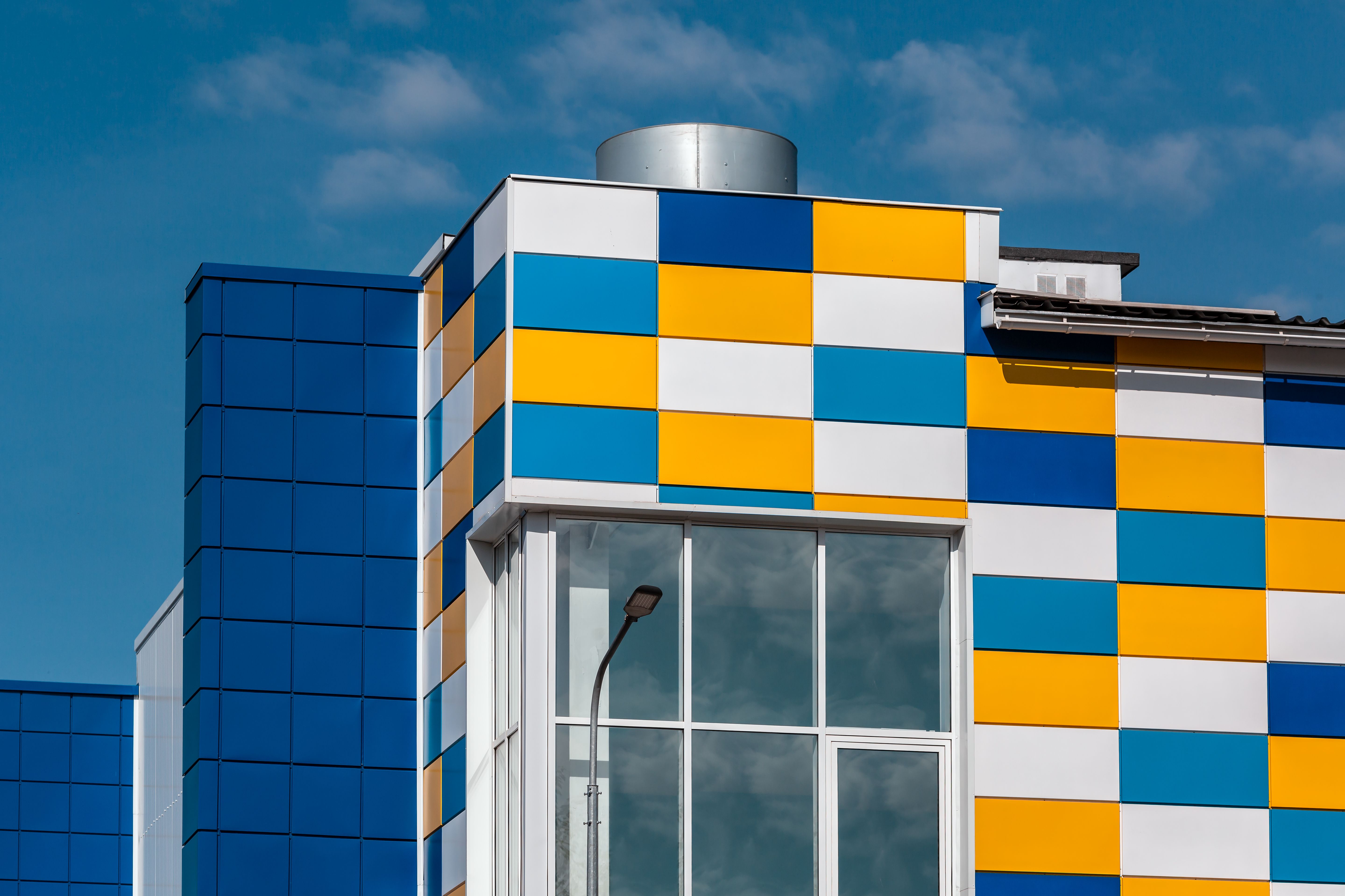Facade of a Modern Building with Blue, Yellow and White Tiles on the ...