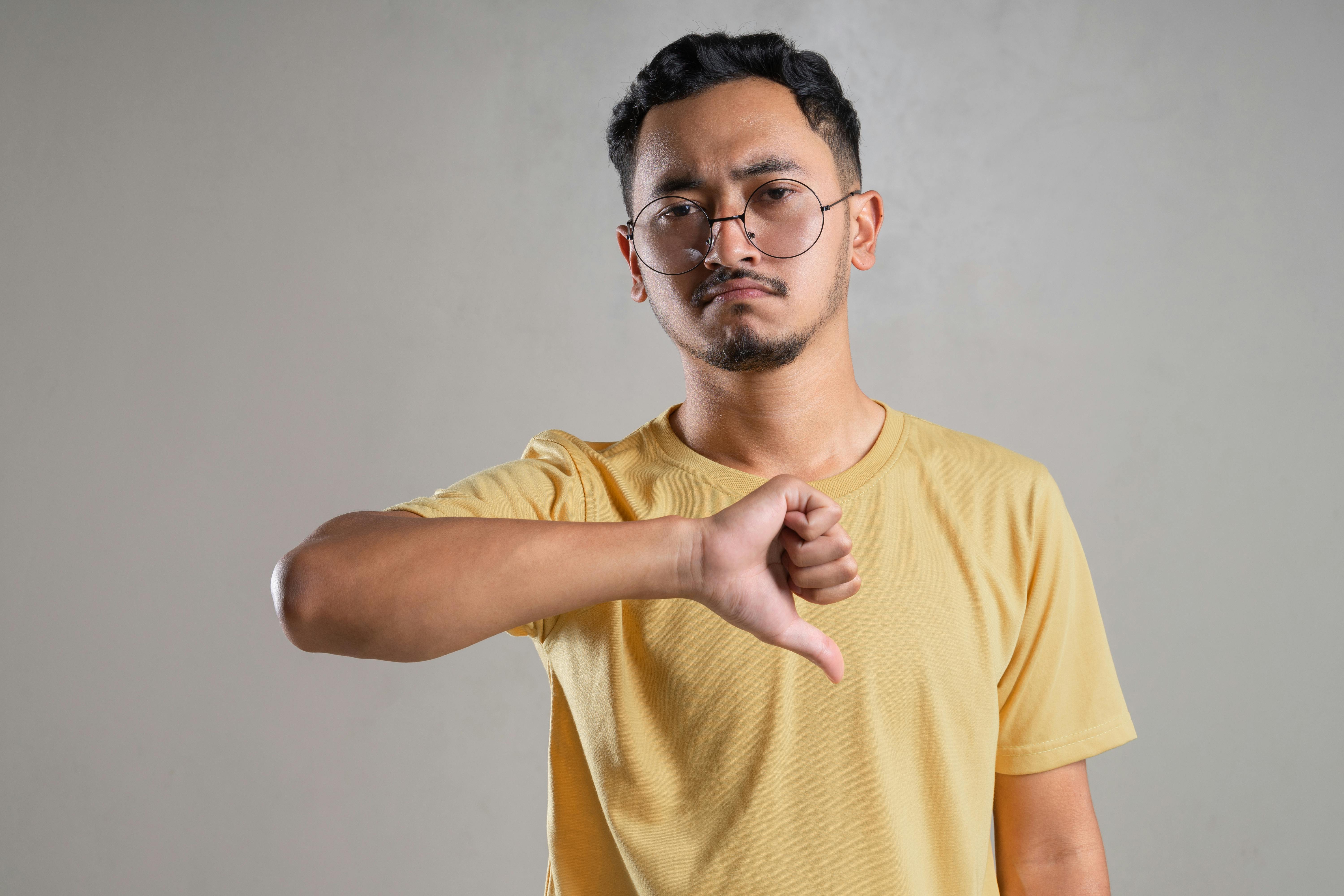 A Man Wearing Eyeglasses Doing Thumbs Down · Free Stock Photo