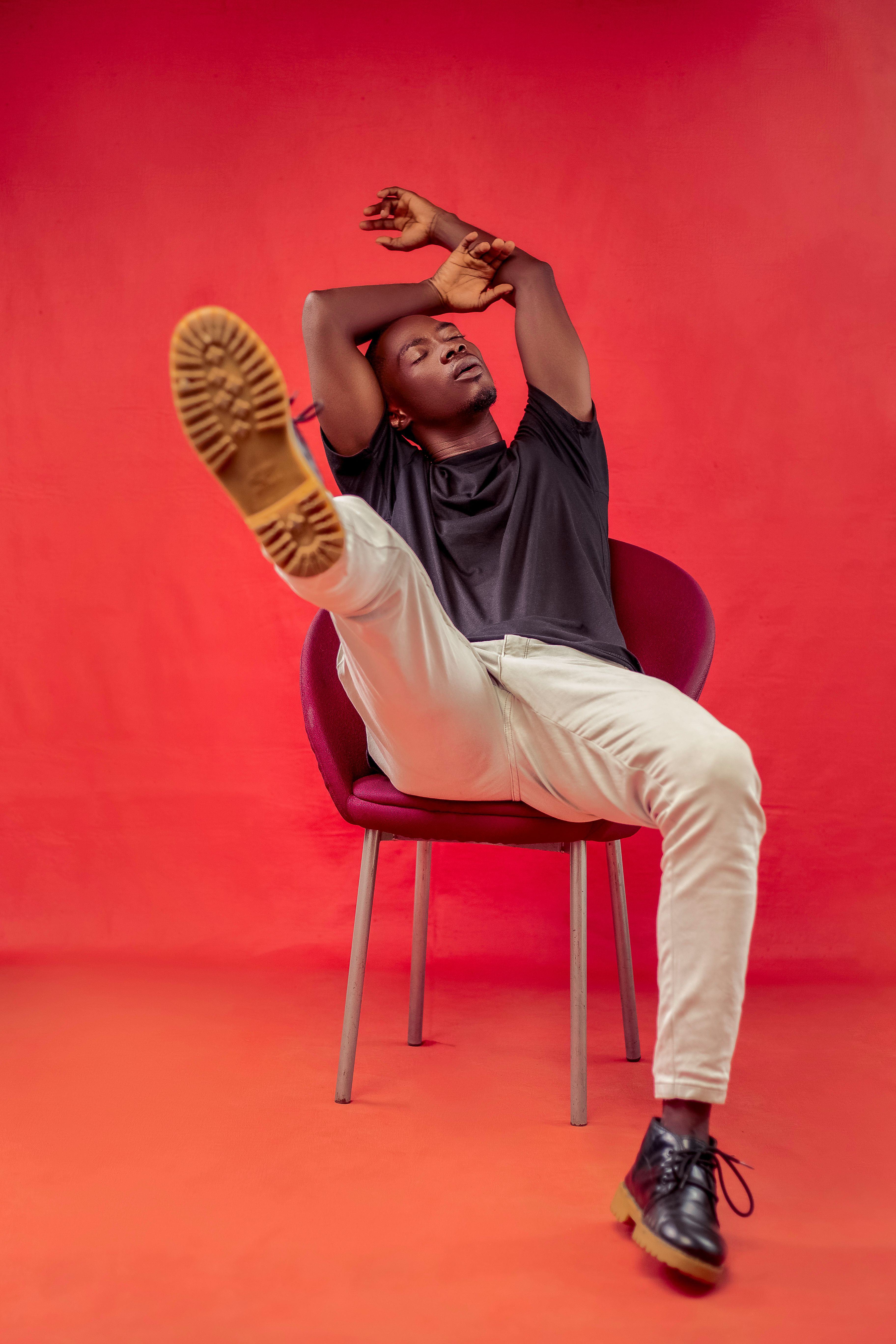 Man Sitting in Red Chair with Leg Up · Free Stock Photo