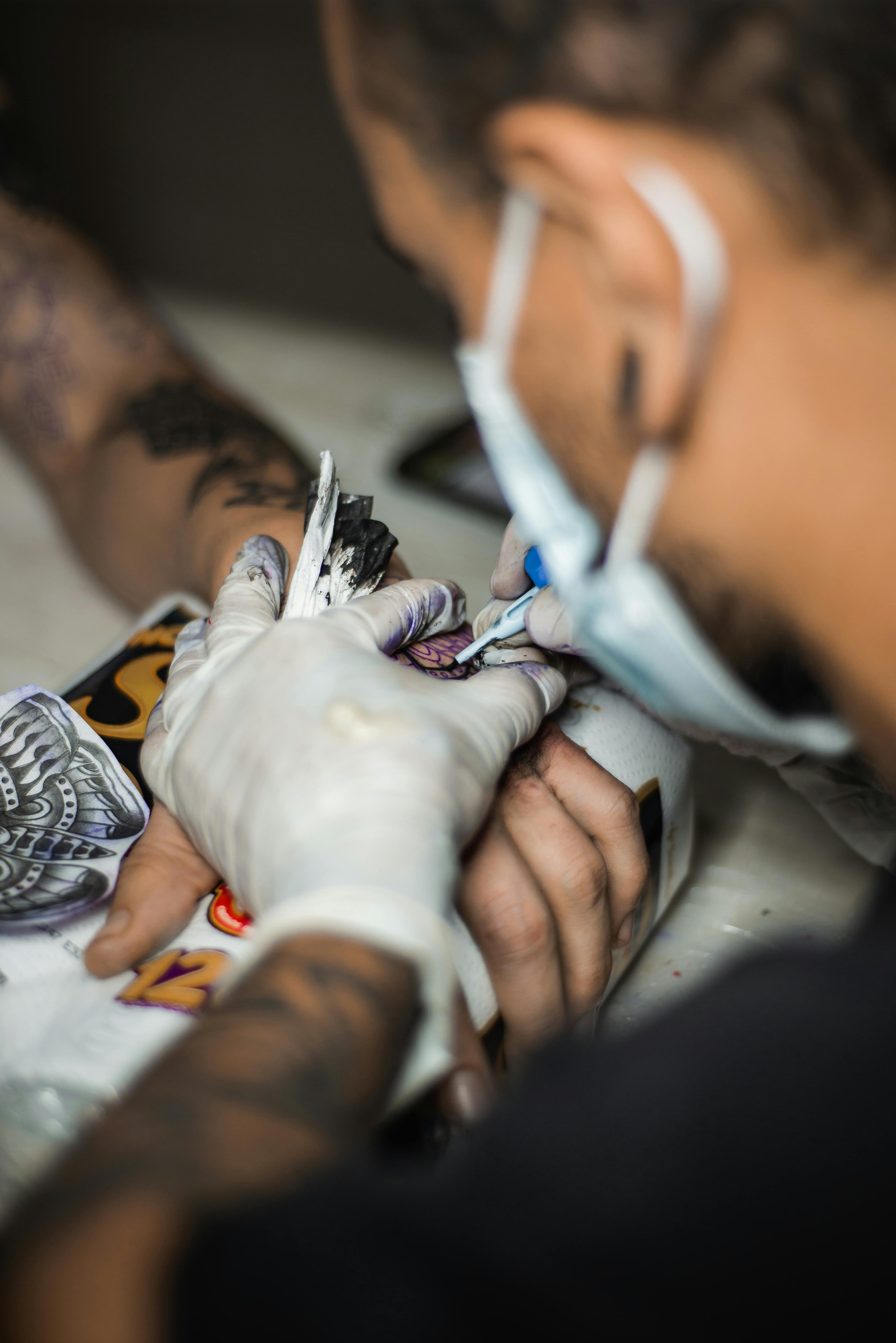 A Man Tattooing a Person · Free Stock Photo