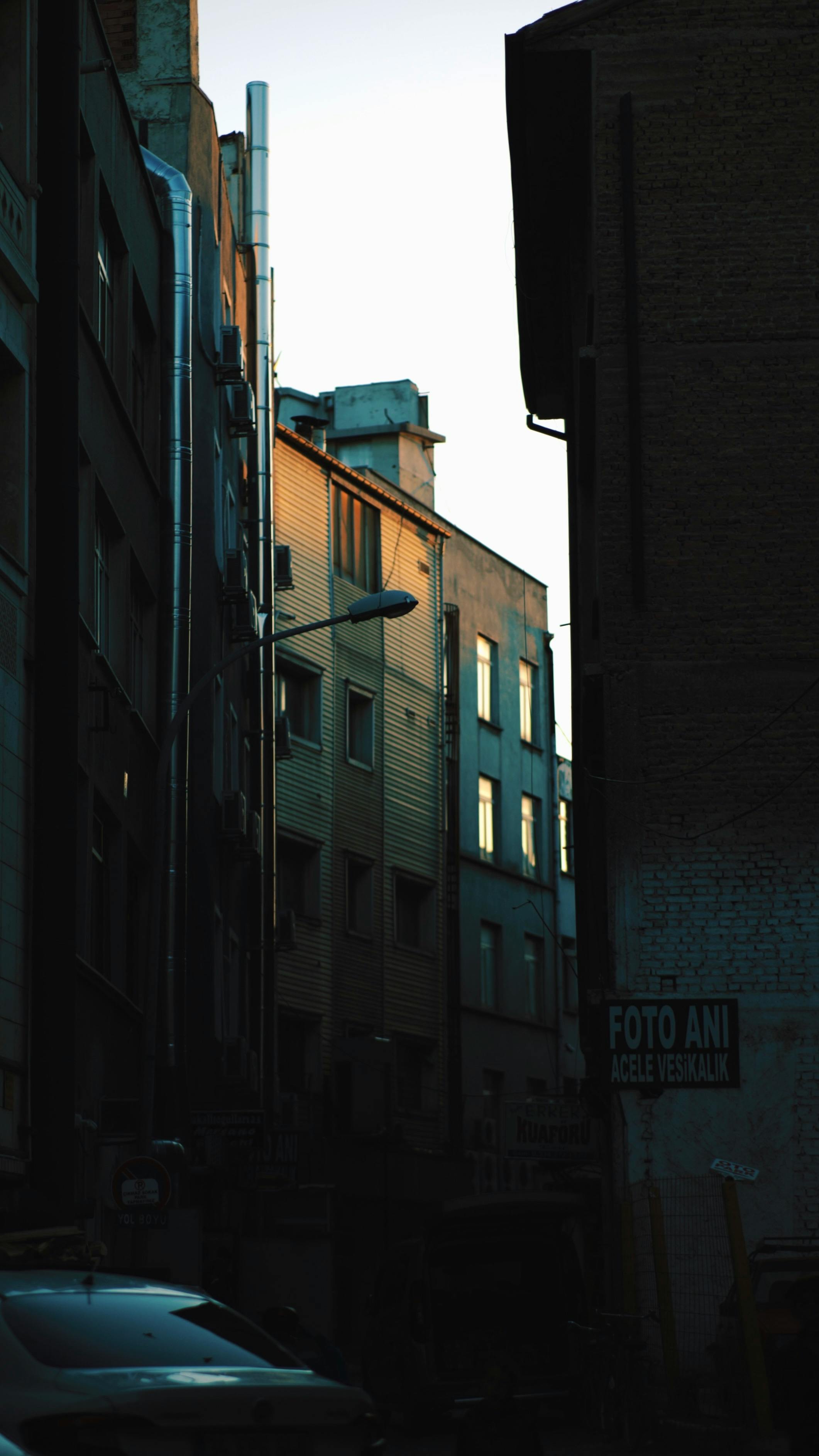 People Walking on an Inclined Street Between Buildings · Free Stock Photo