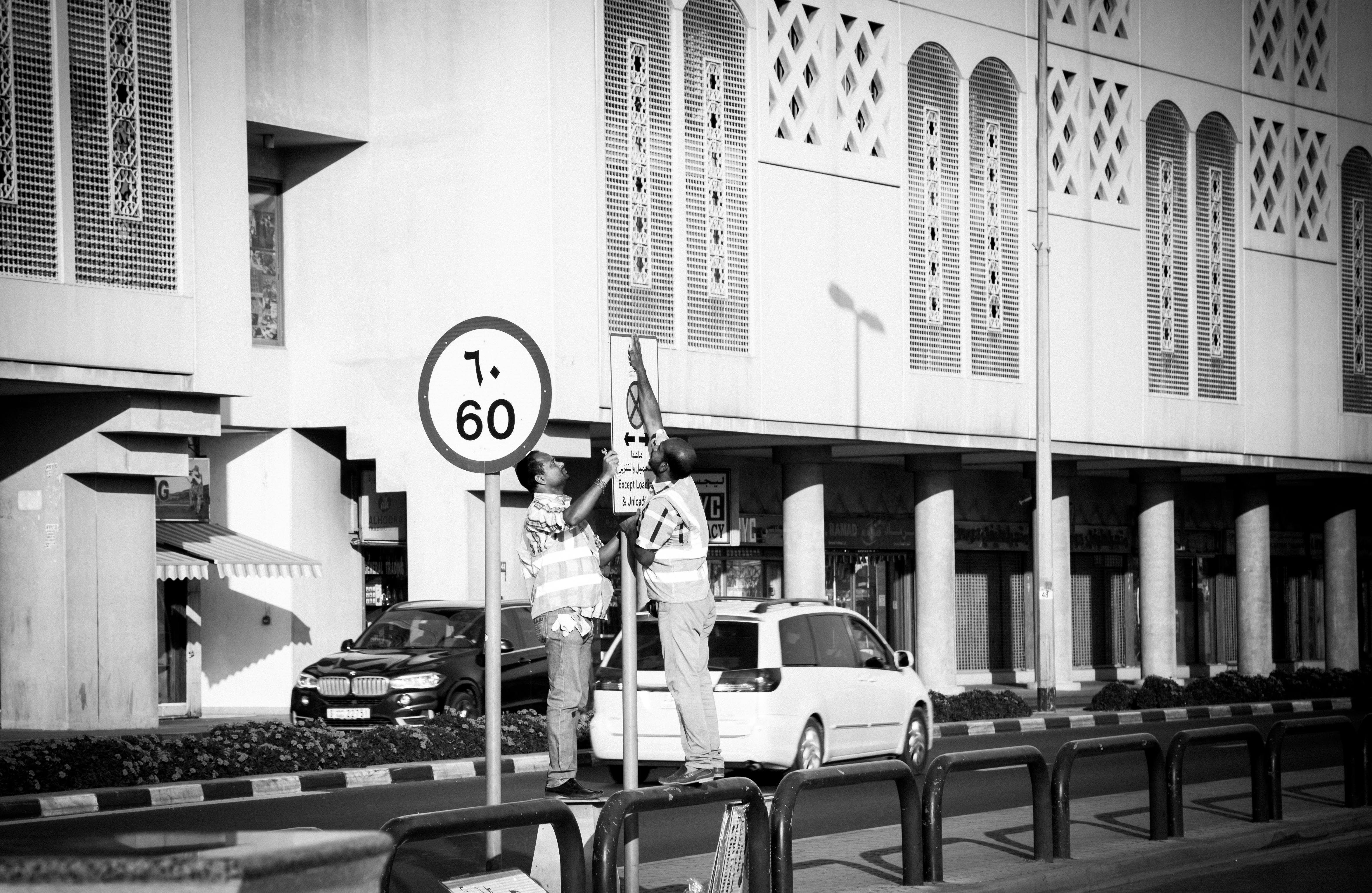 Men Fixing a Signboard · Free Stock Photo