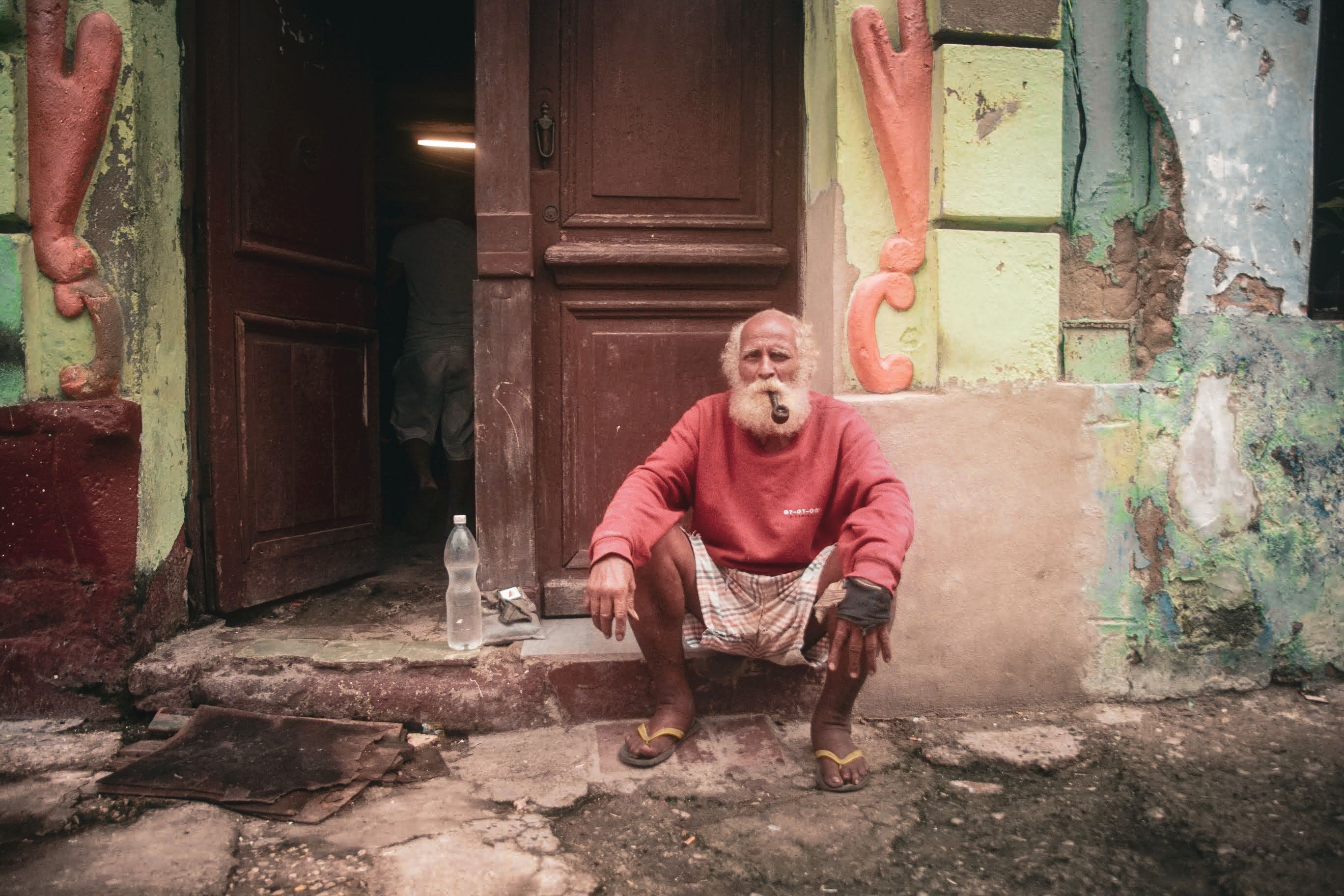 Shirtless Man Sitting on a Threshold · Free Stock Photo