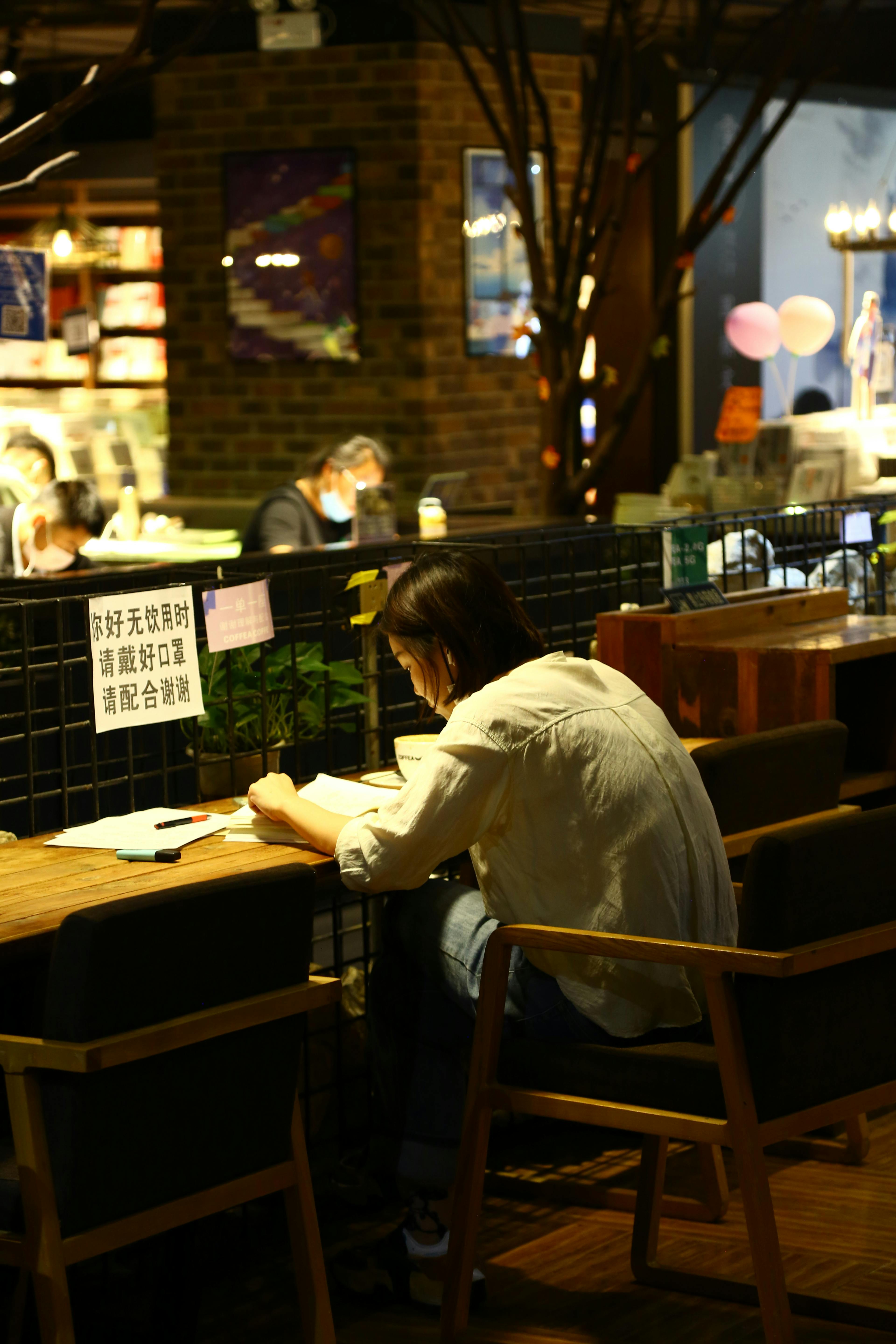 Woman reading a Book while leaning on a Window Pane · Free Stock Photo