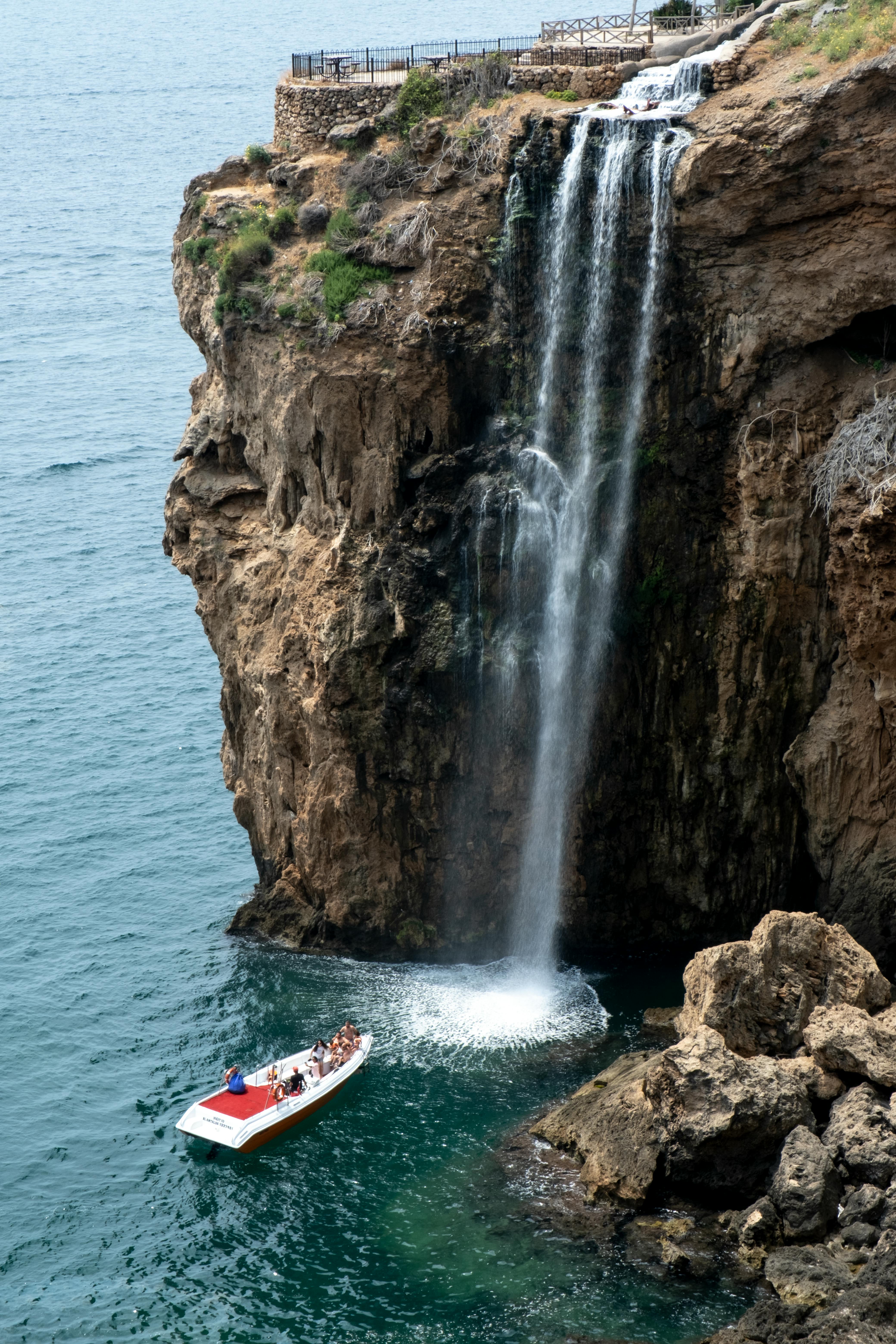 Waterfall on Cliff and Boat · Free Stock Photo