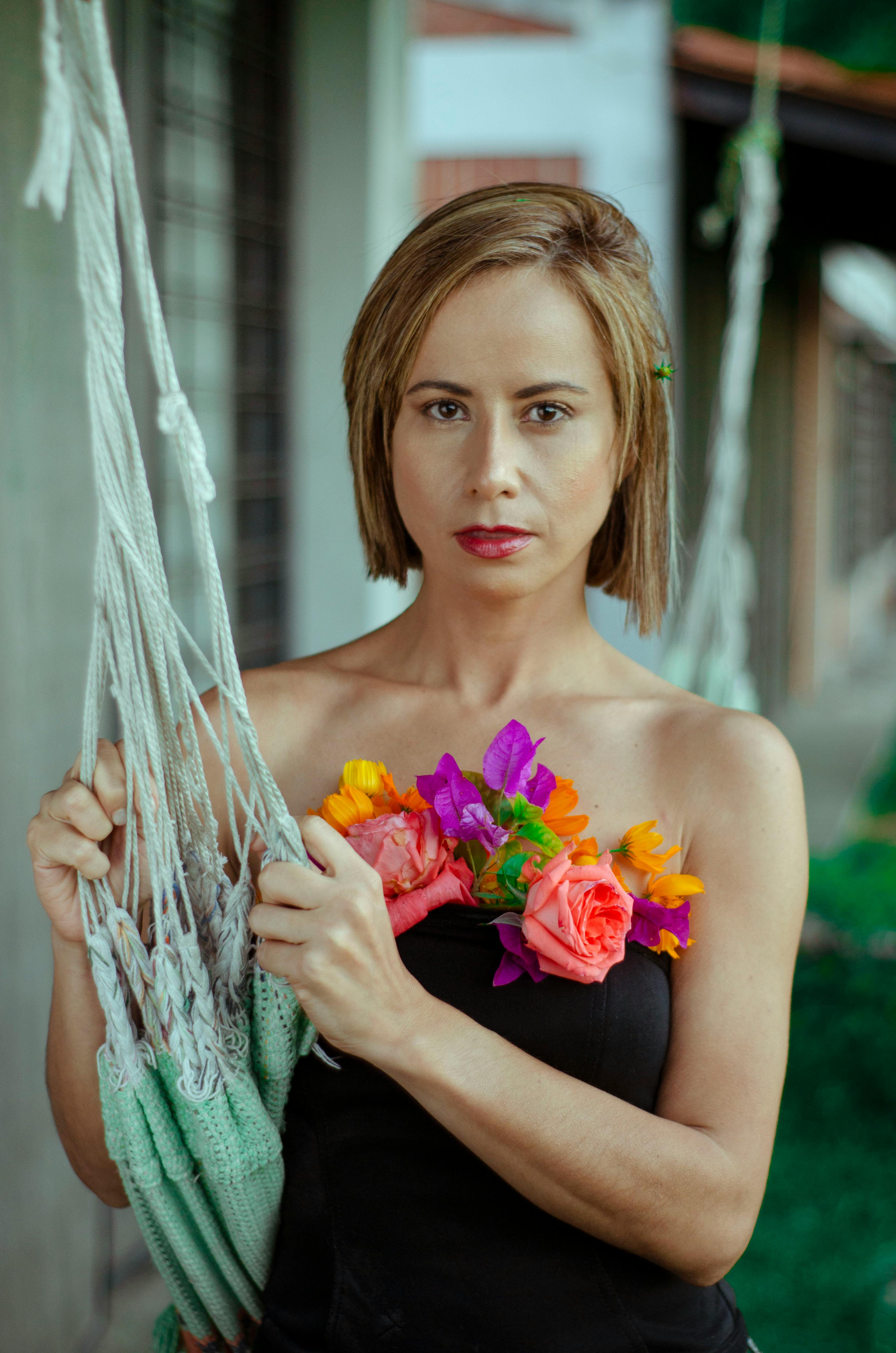 Woman with Flowers on Chest Holding on the Hammock · Free Stock Photo