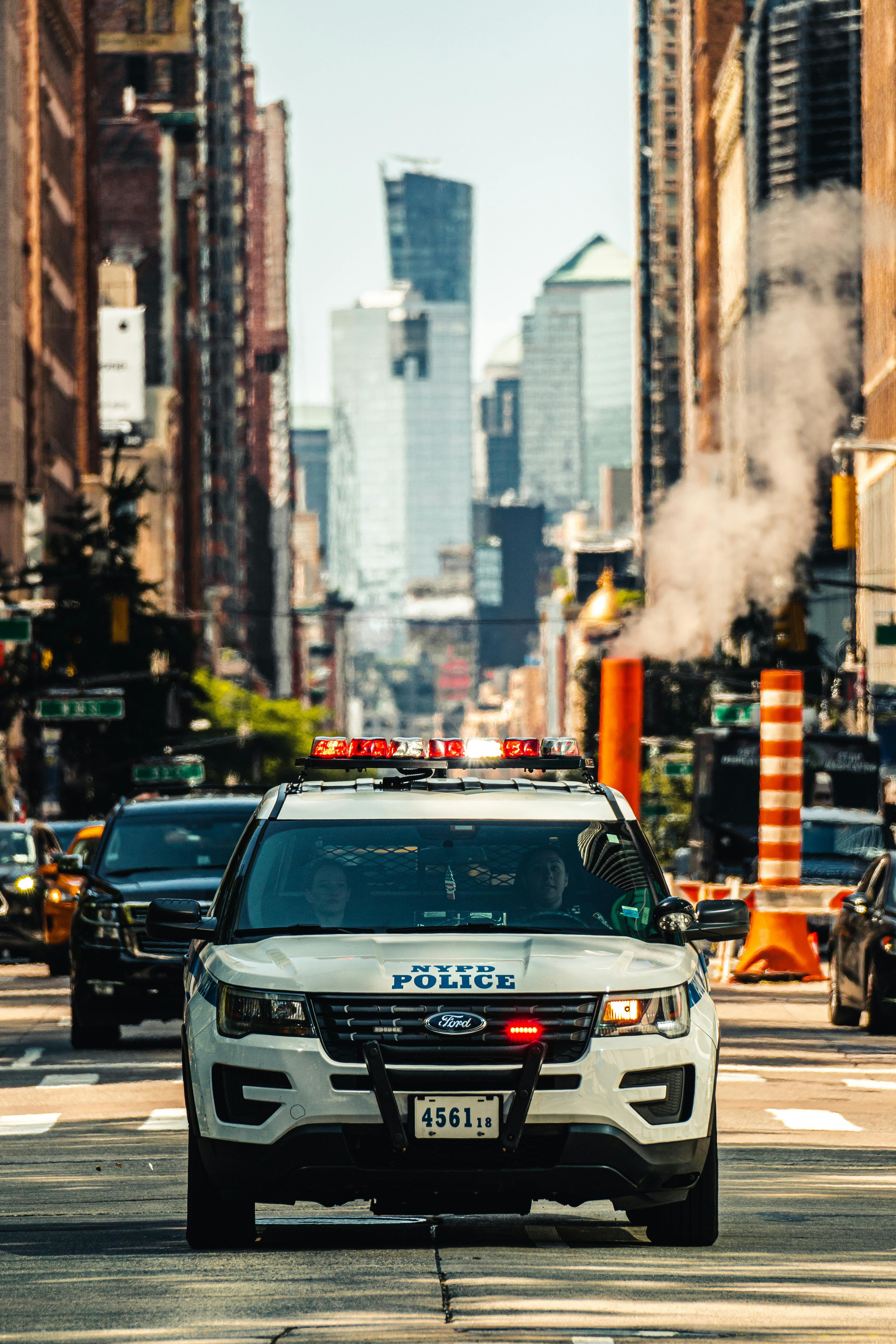 A White Police Car Traveling the Street · Free Stock Photo