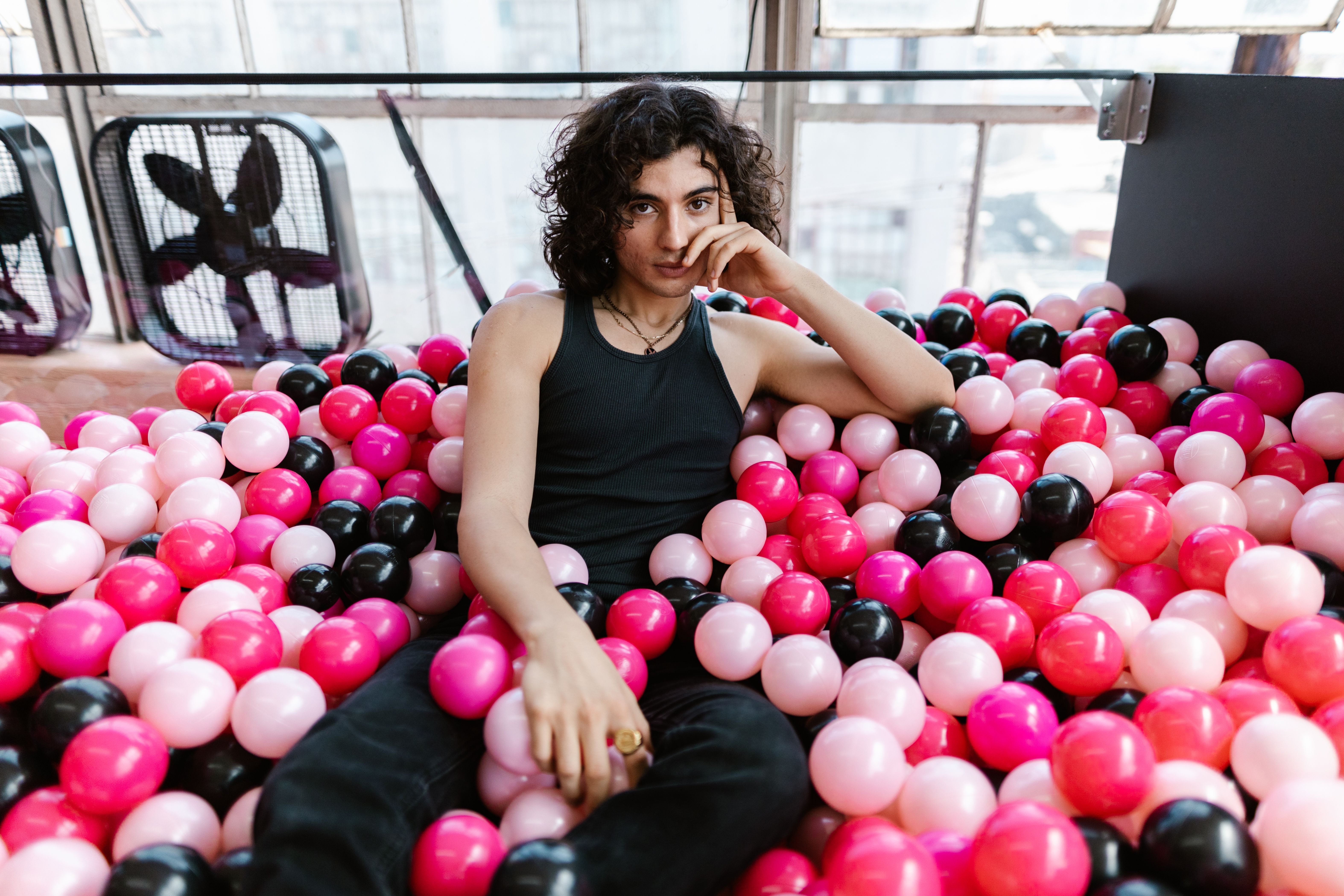 Man Sitting amidst Plastic Balls · Free Stock Photo