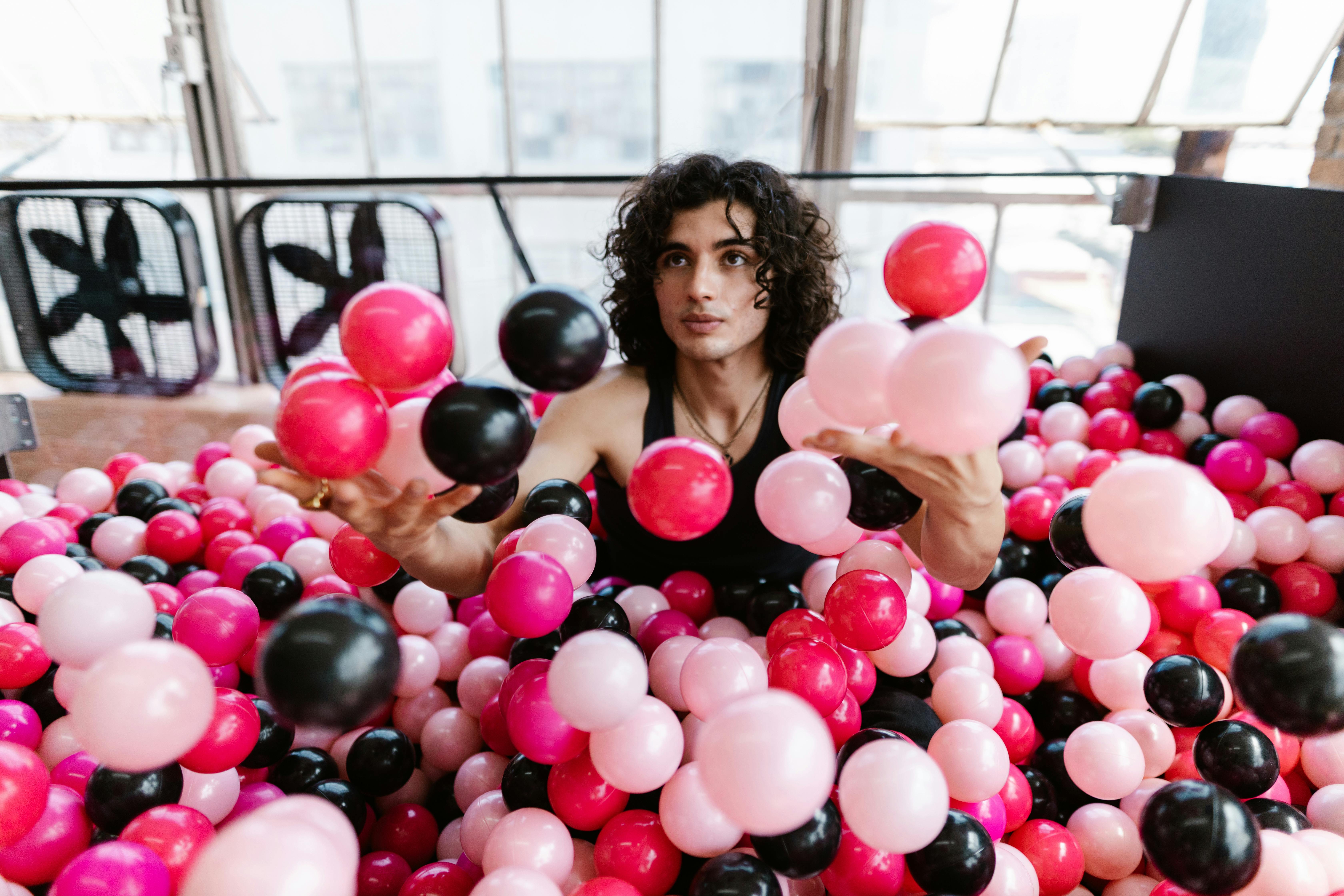 Man Sitting in a Ball Pit Pool · Free Stock Photo