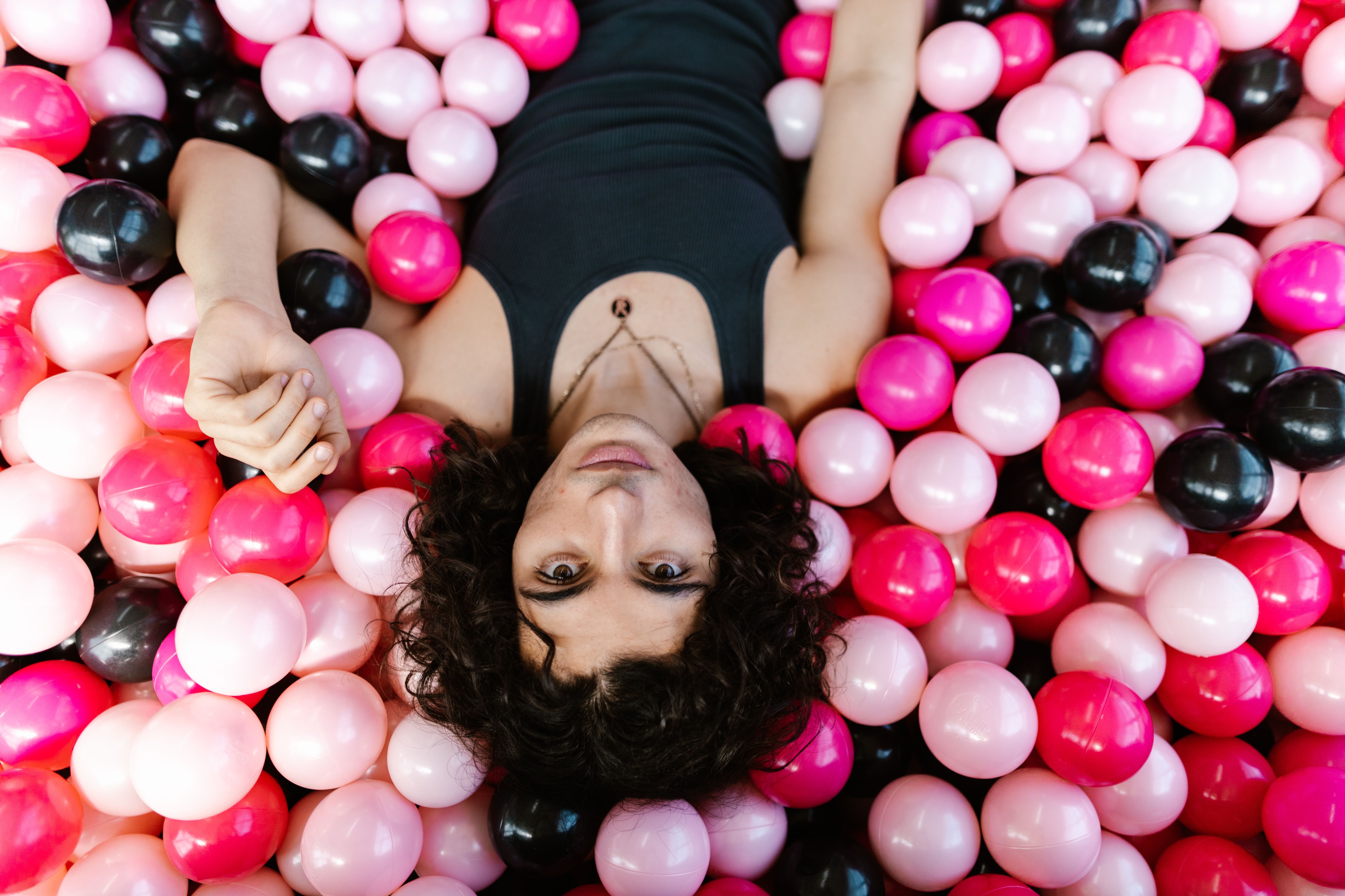 Man Lying in a Pool of Plastic Balls · Free Stock Photo