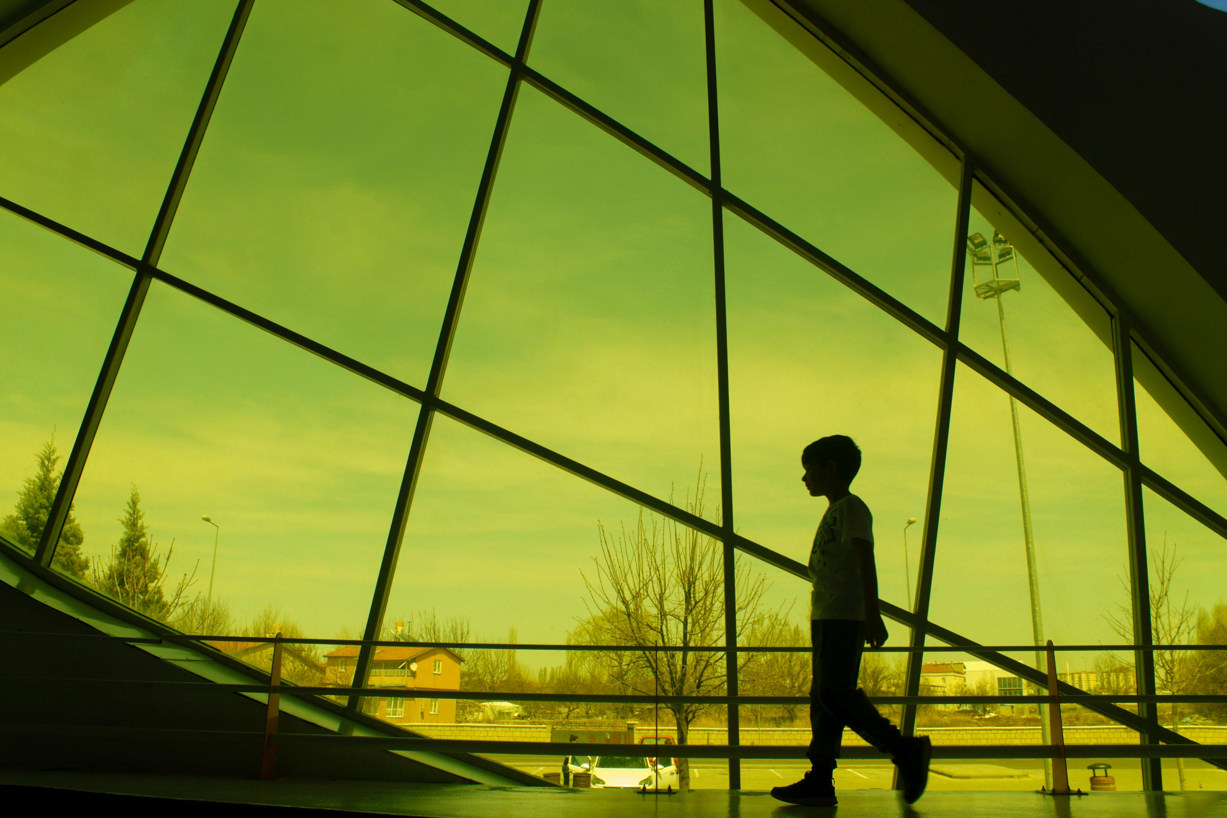 Boy Walking near Windows · Free Stock Photo