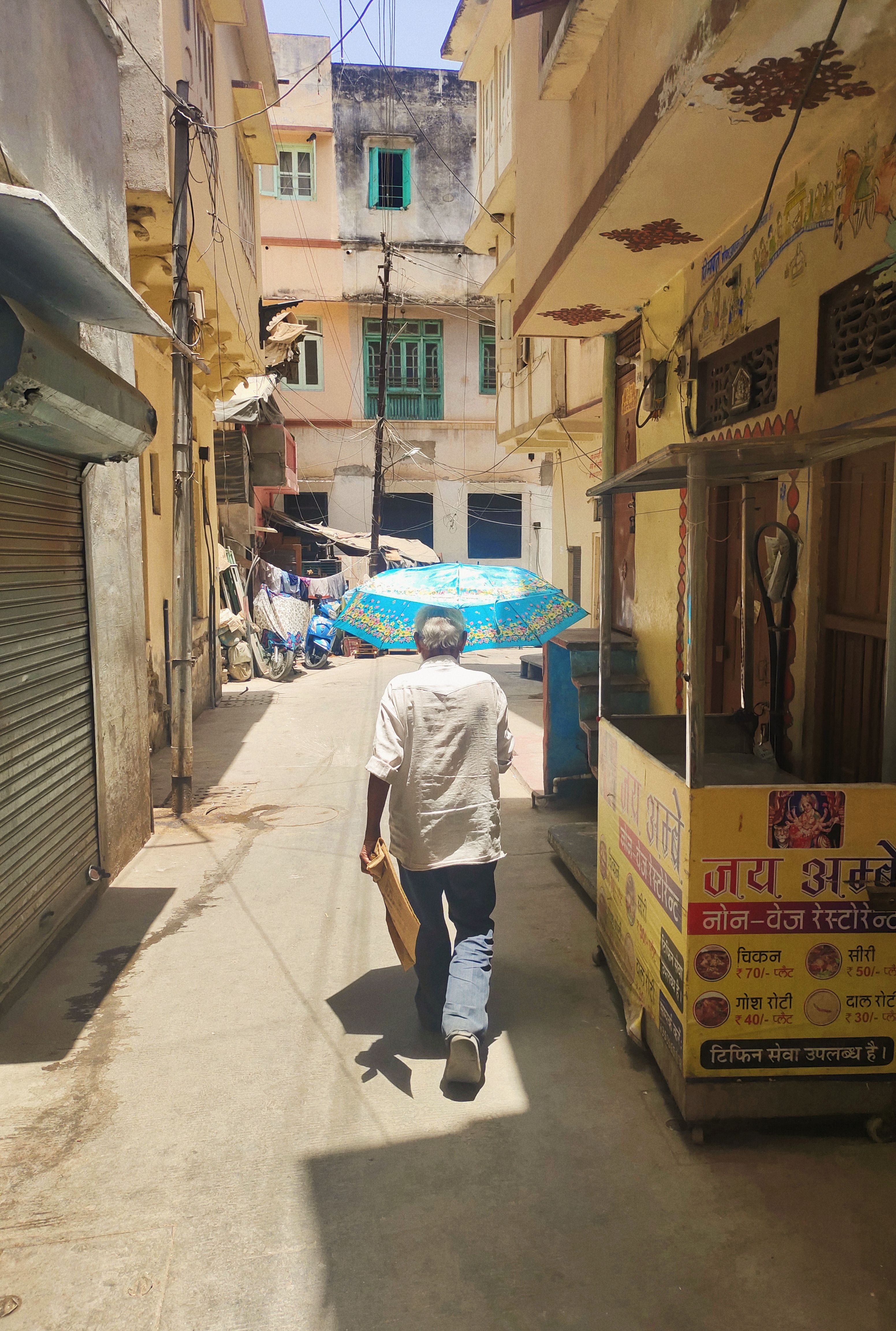 A Man Walking on the Street Between Buildings · Free Stock Photo