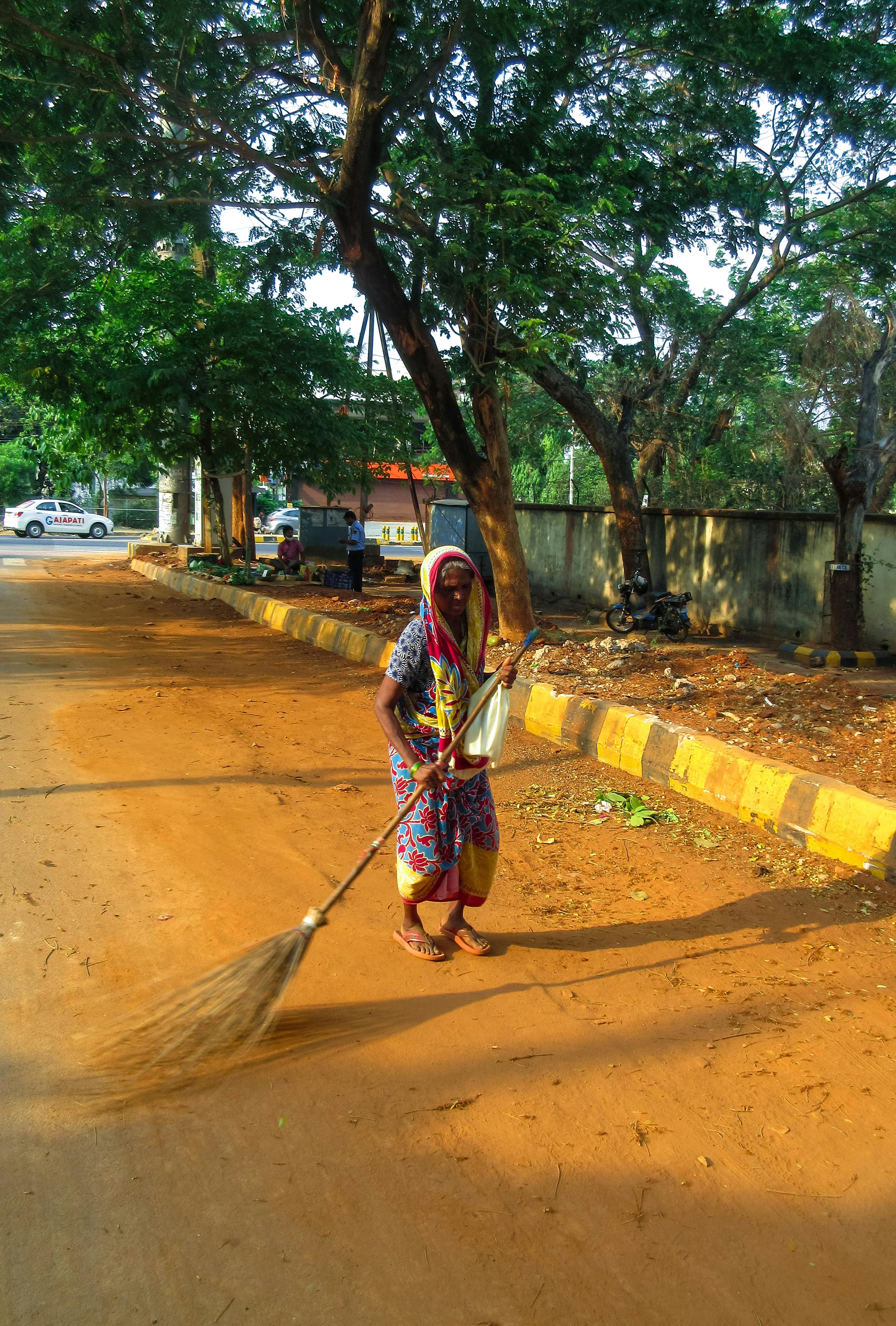 A Woman Sweeping on the Street · Free Stock Photo