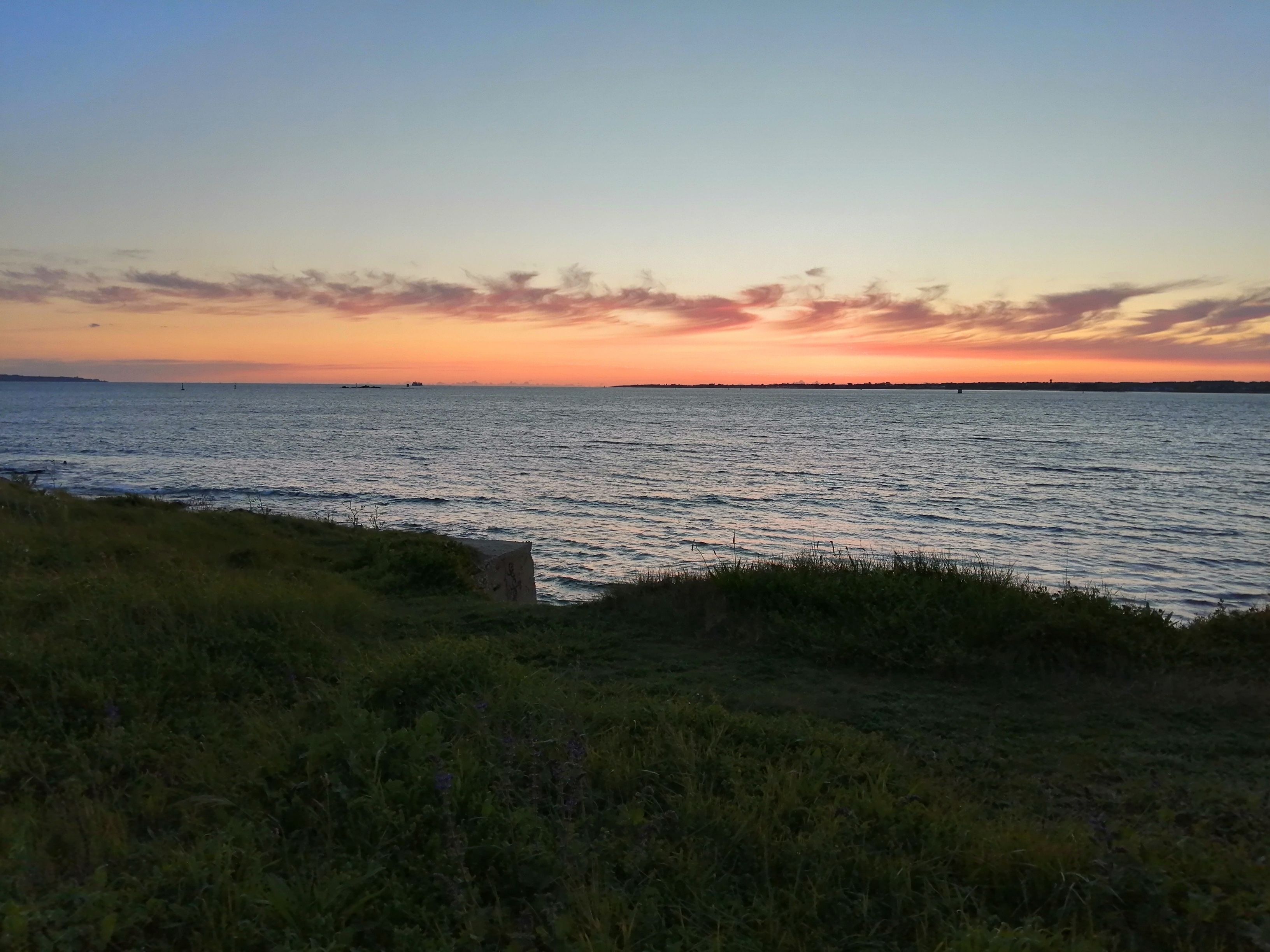 Green Grass Field Next to the Ocean at Sunset · Free Stock Photo