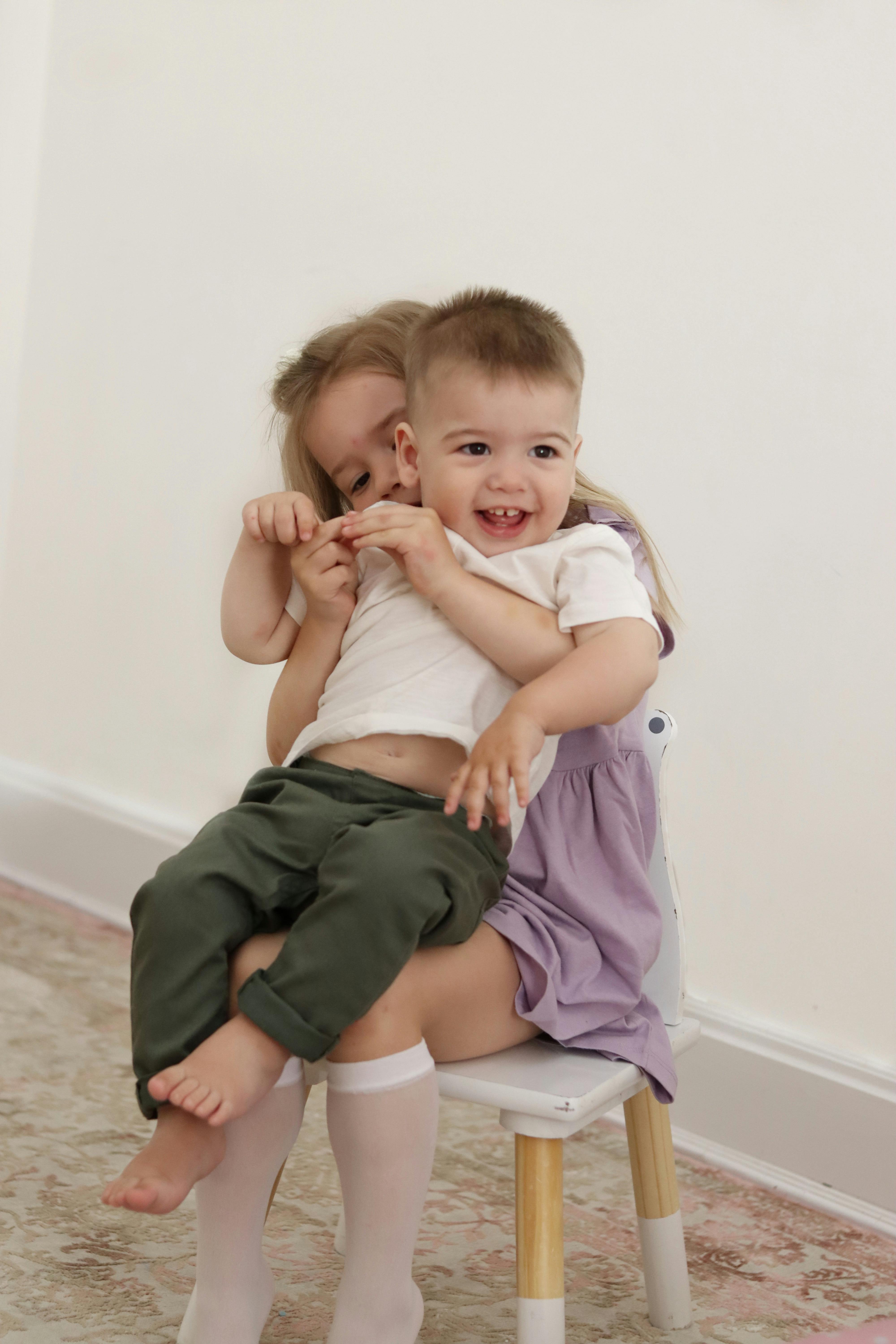 A Toddler Sitting on Her Sisters Lap · Free Stock Photo