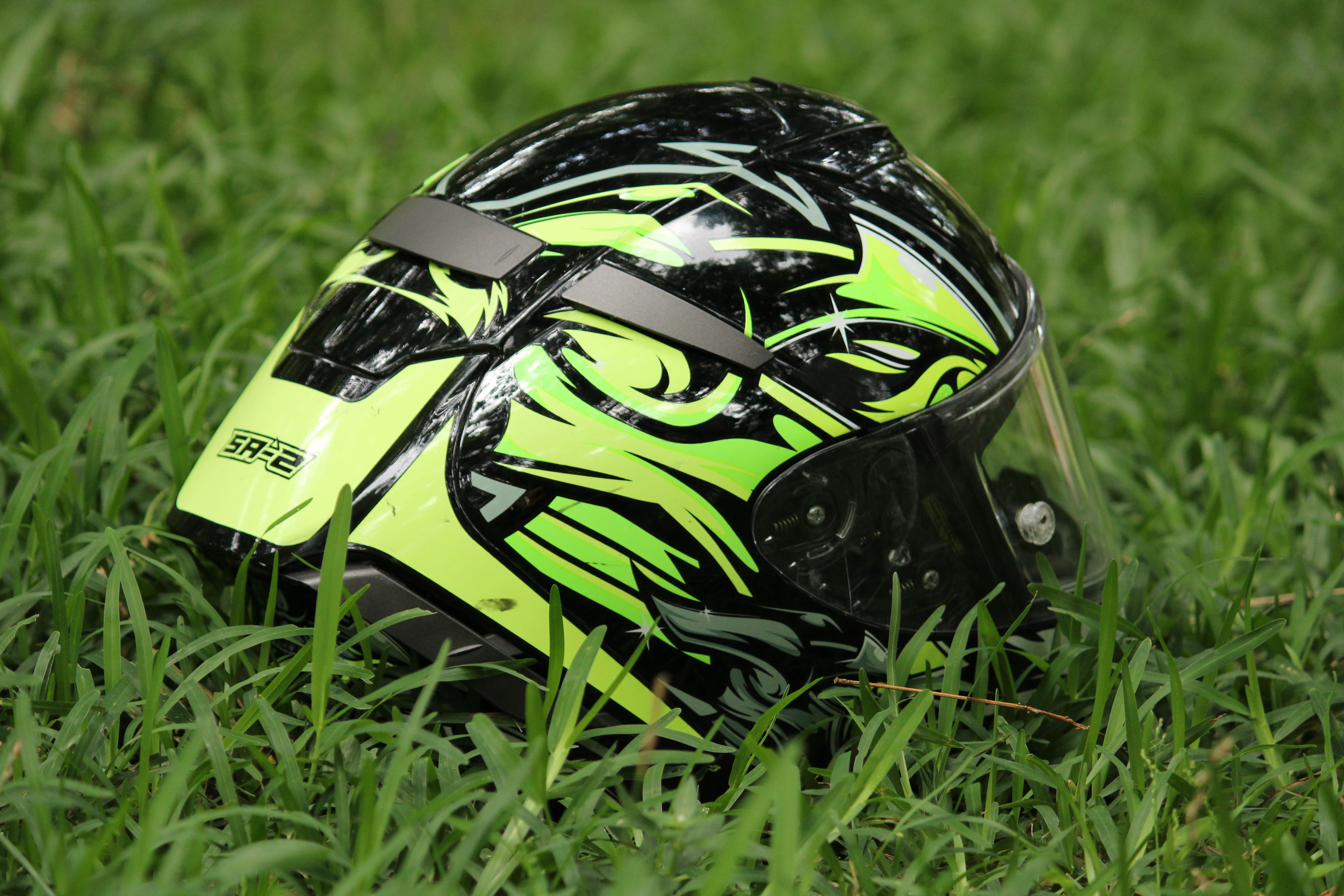 Close-Up Shot of a Motorcycle Helmet on Green Grass · Free Stock Photo