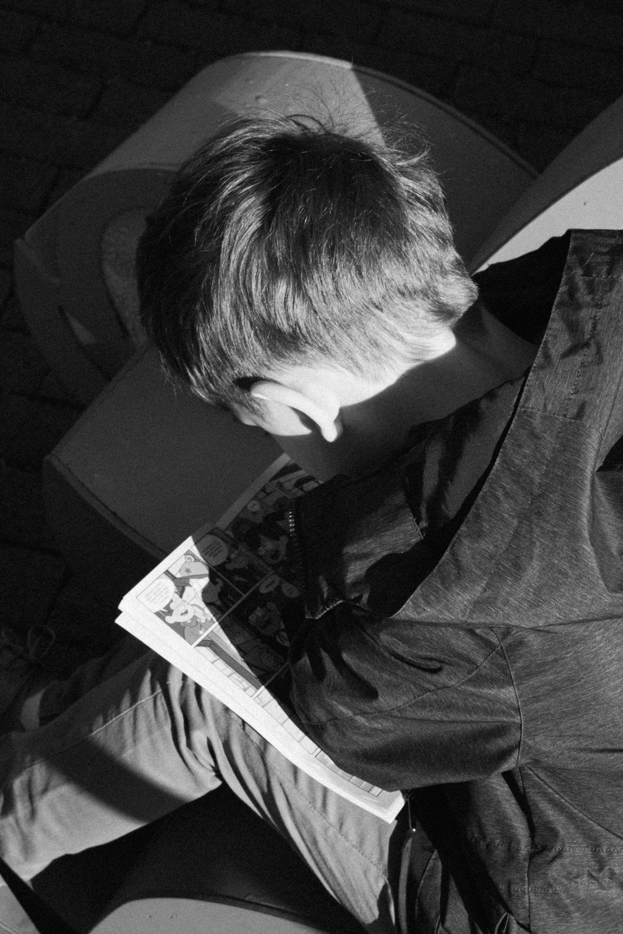 A Grayscale of a Person Reading a Comic Book · Free Stock Photo