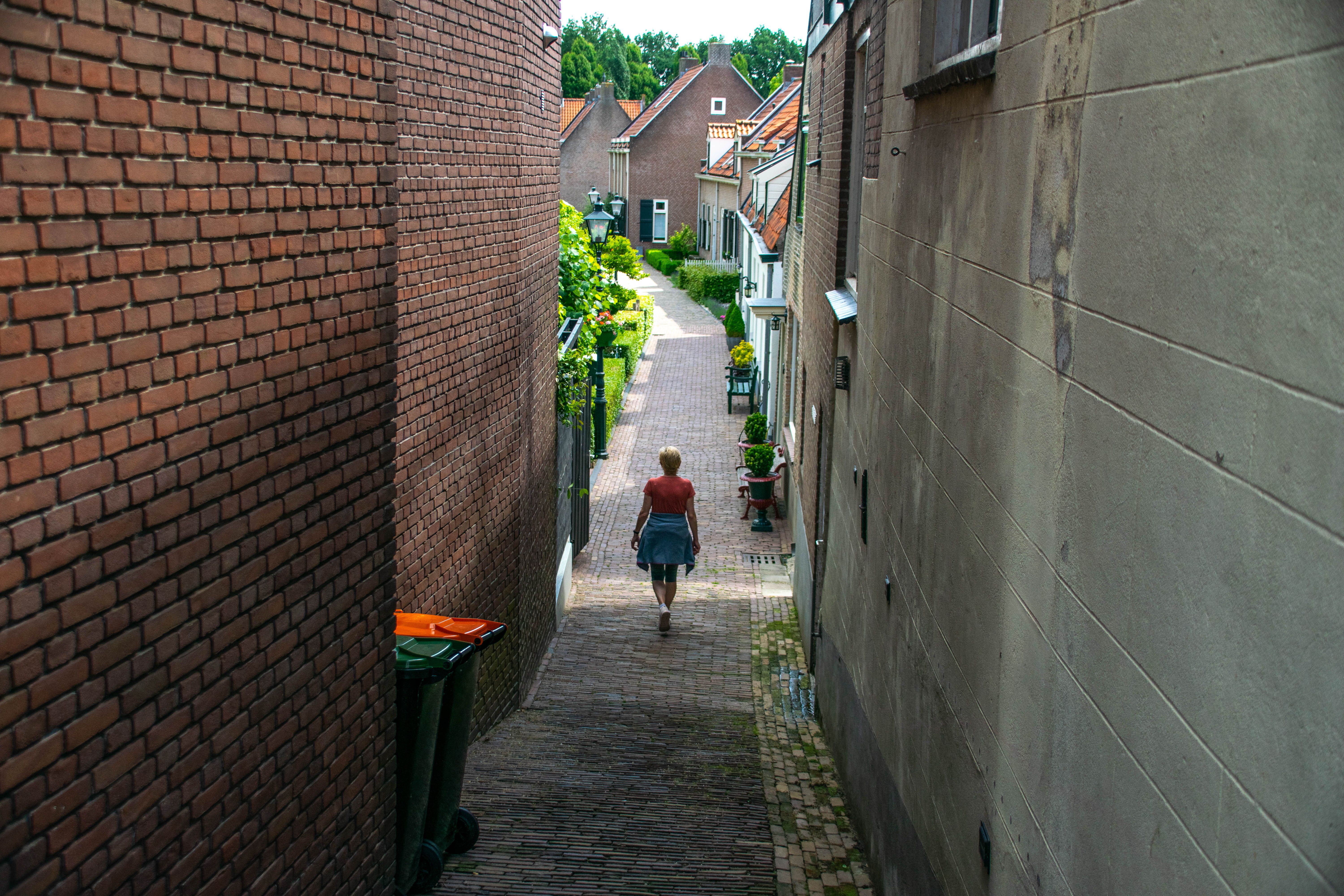 Back View of a Person Walking on Alleyway · Free Stock Photo