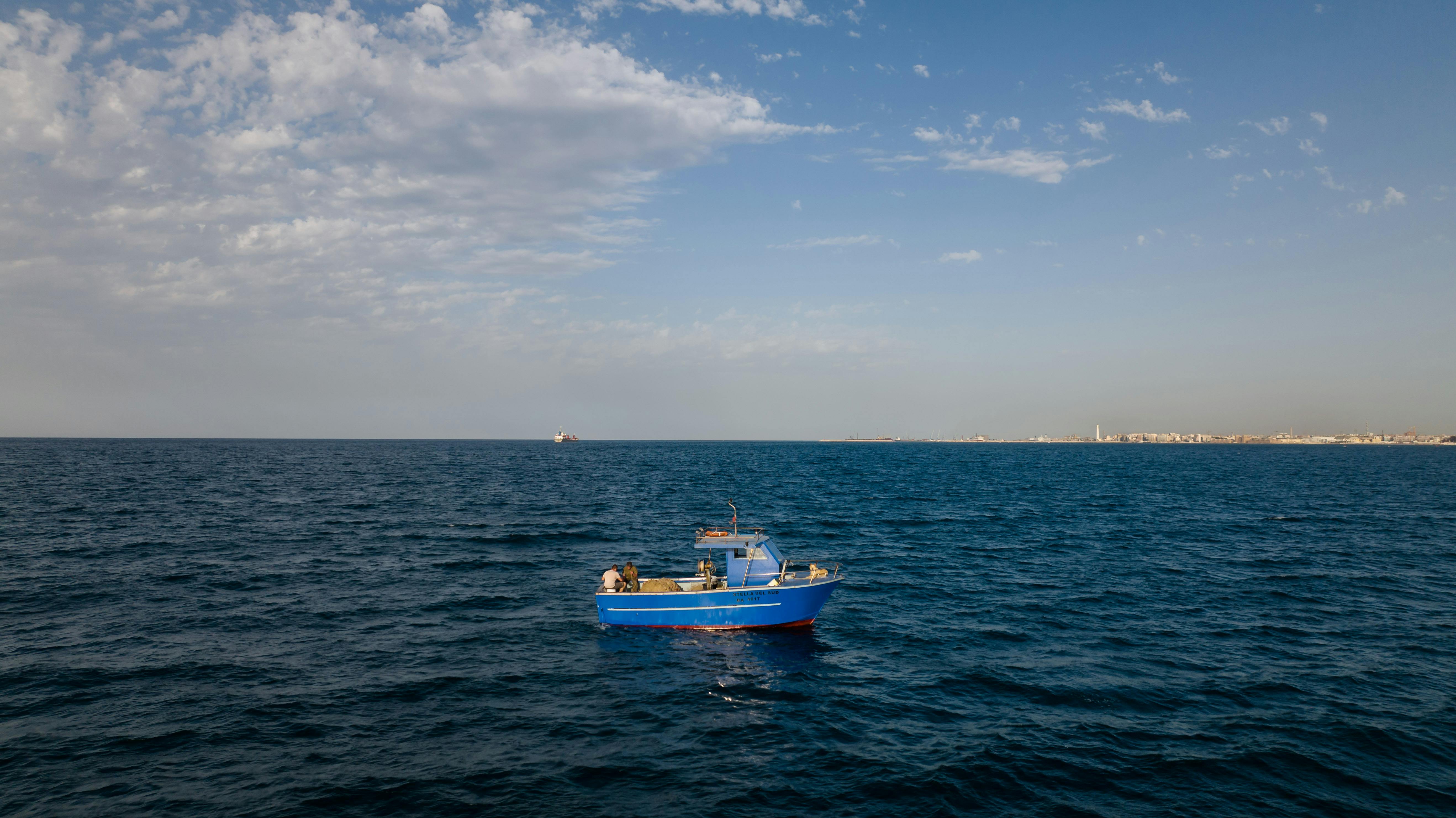 A Blue Boat on Water Under a Blue Sky · Free Stock Photo