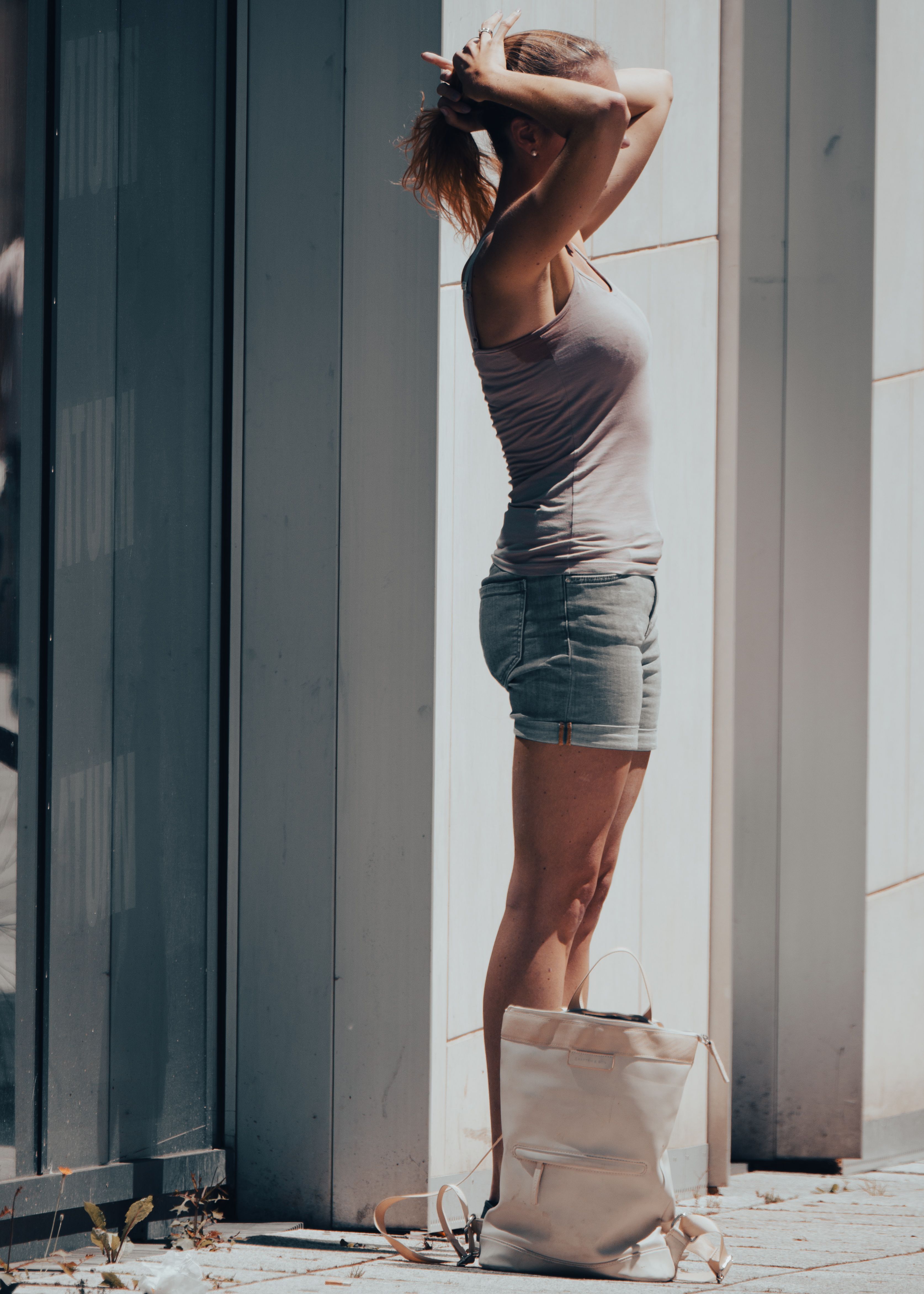 Back of a Woman Fixing her Hair on a Roof · Free Stock Photo