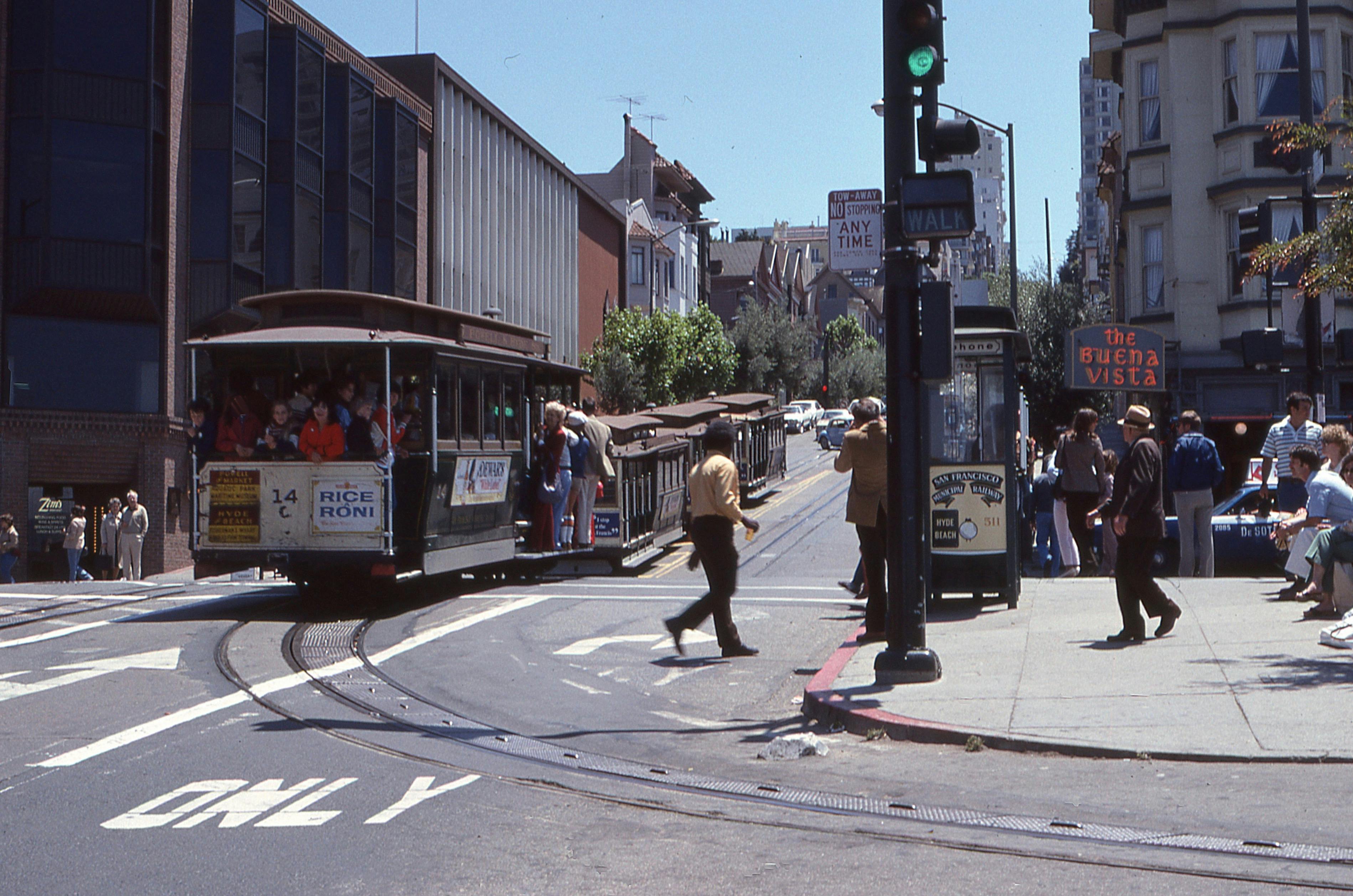 A Tram with Passengers Passing the Street Near Passersby · Free Stock Photo
