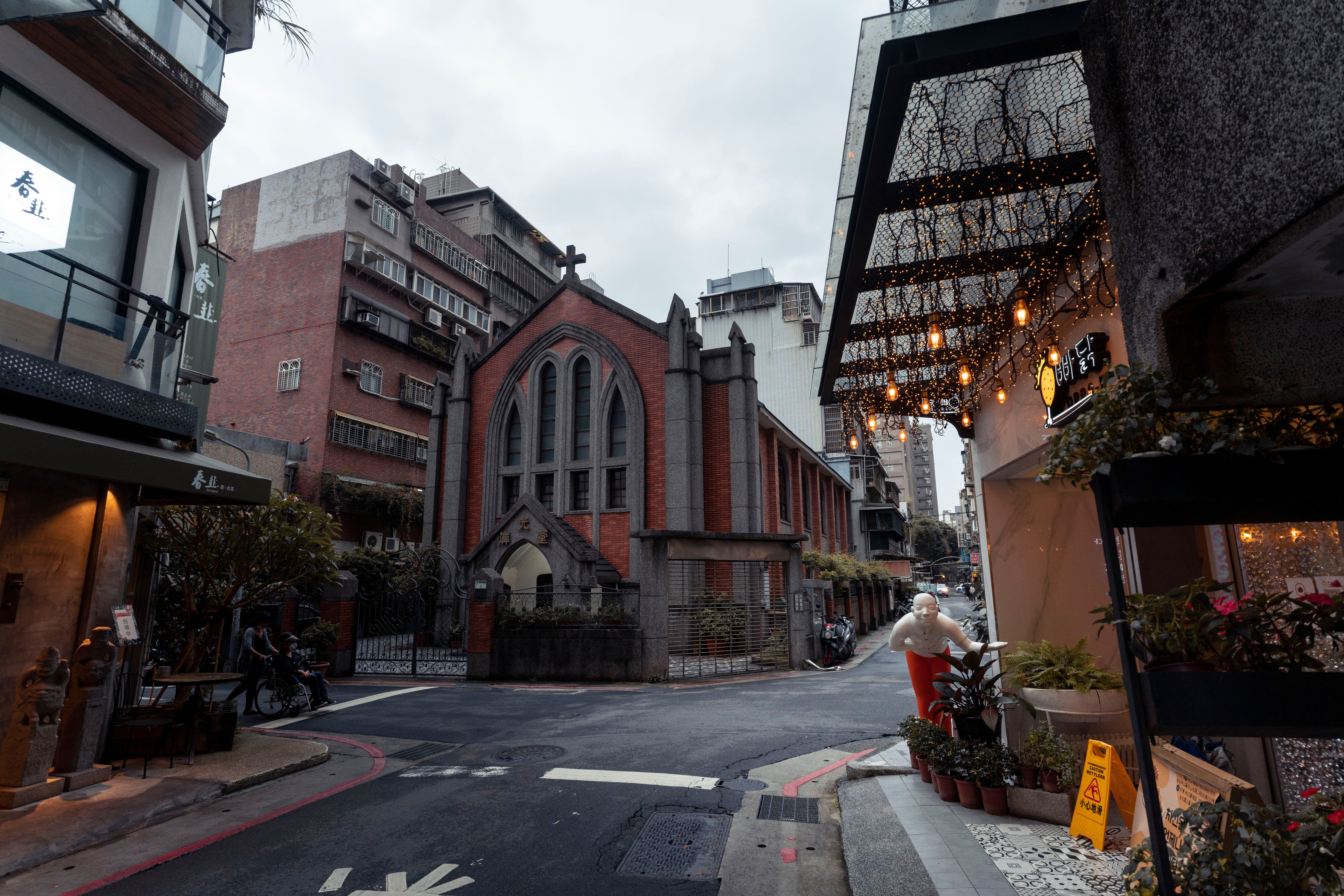 A Church Beside Brown Concrete Building · Free Stock Photo