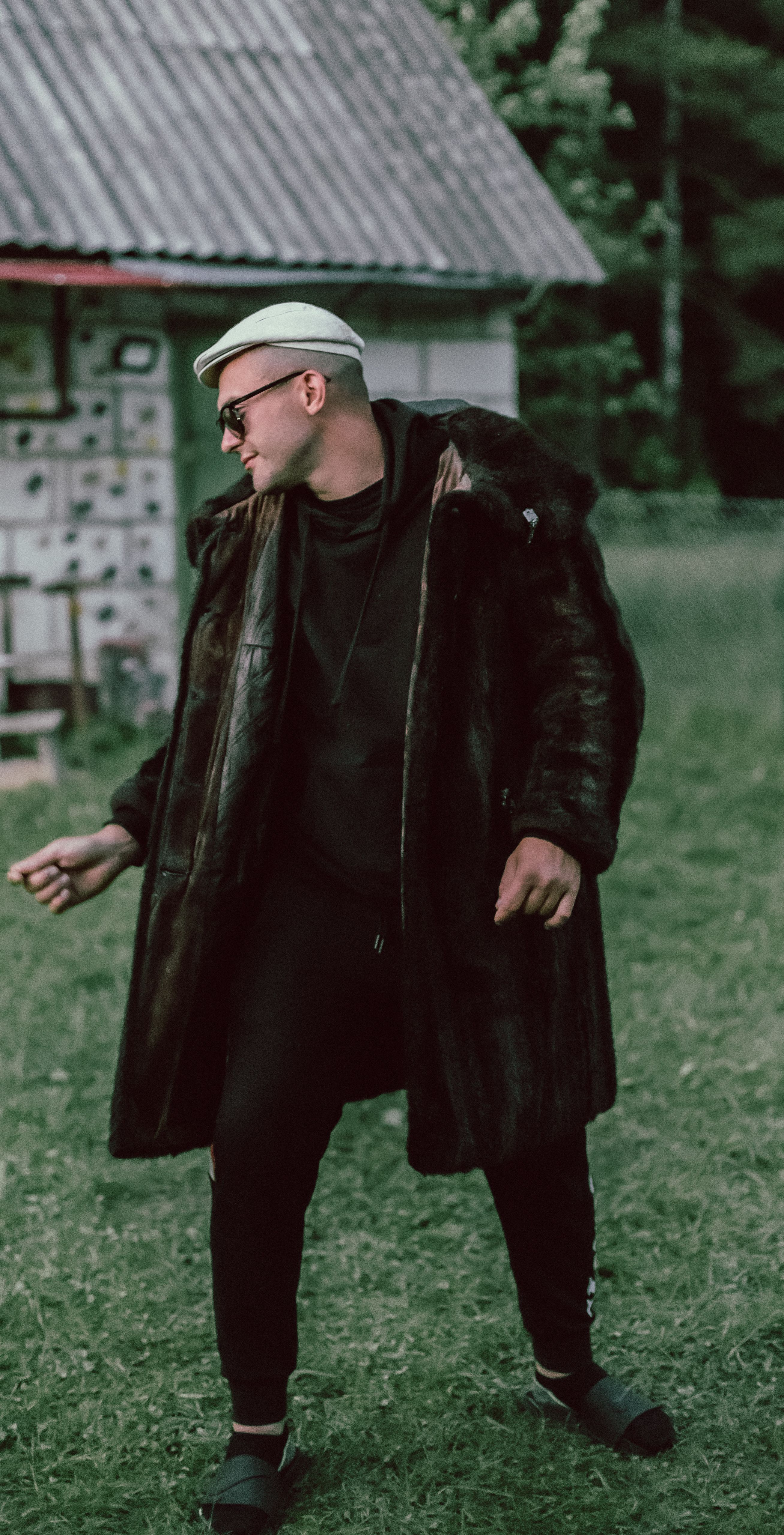 A Man in Flat Cap Wearing Trench Coat while Standing on Grass Field ...