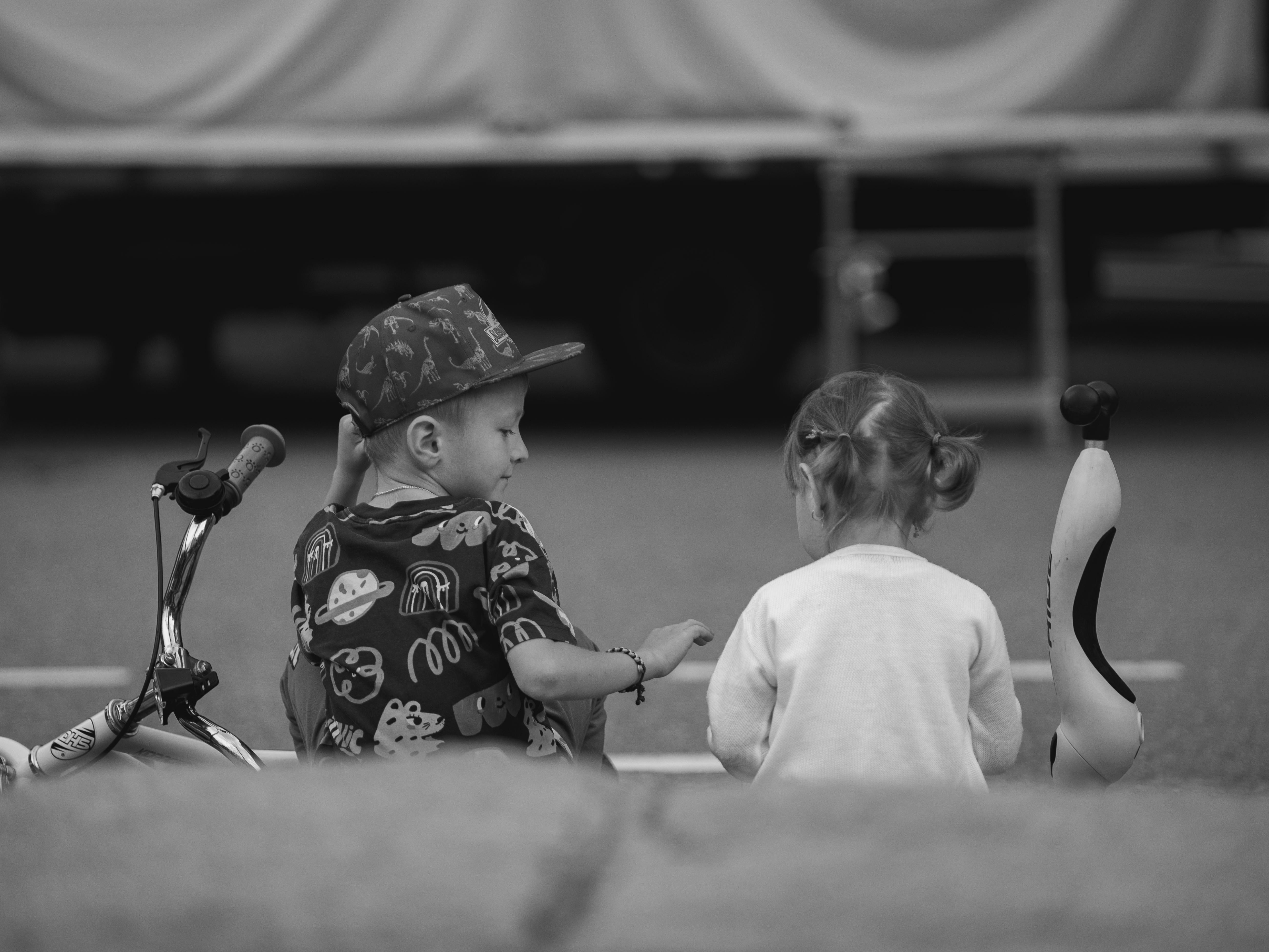 Back View of Two Girls in Traditional Costumes Sitting on the Ground ...