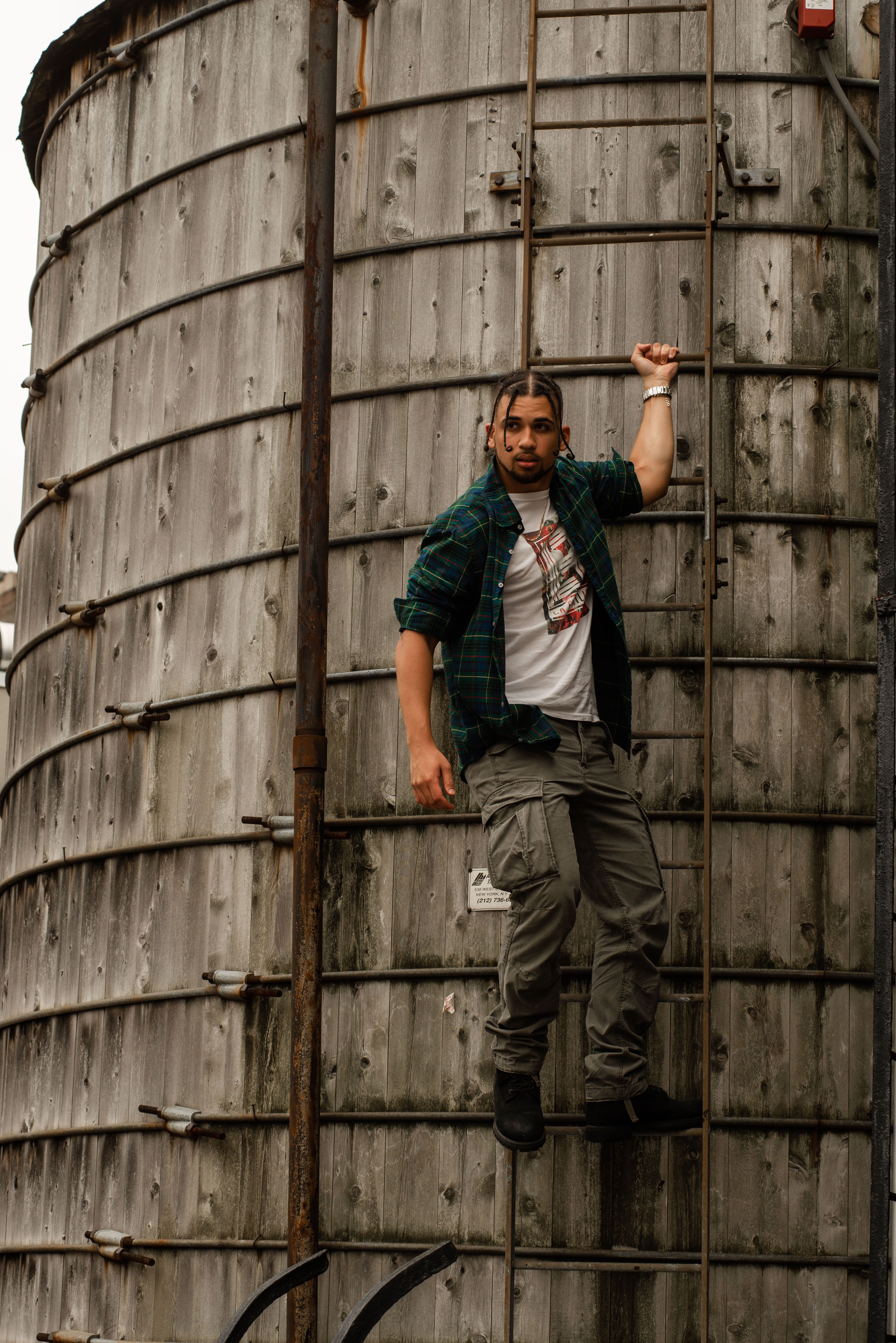 Man Model Climbing Watertower · Free Stock Photo