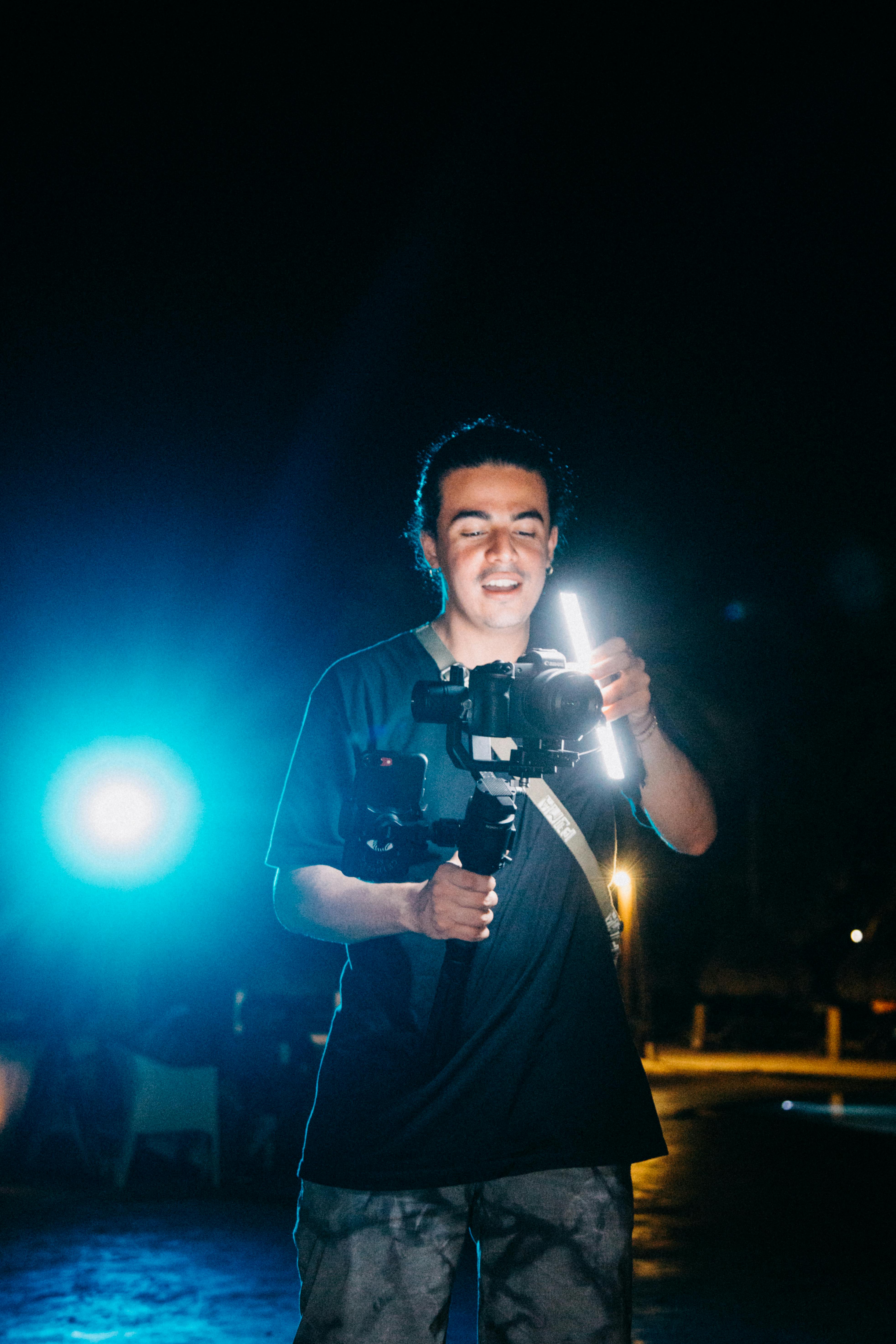 Photographer Holding a Camera in the Dark · Free Stock Photo