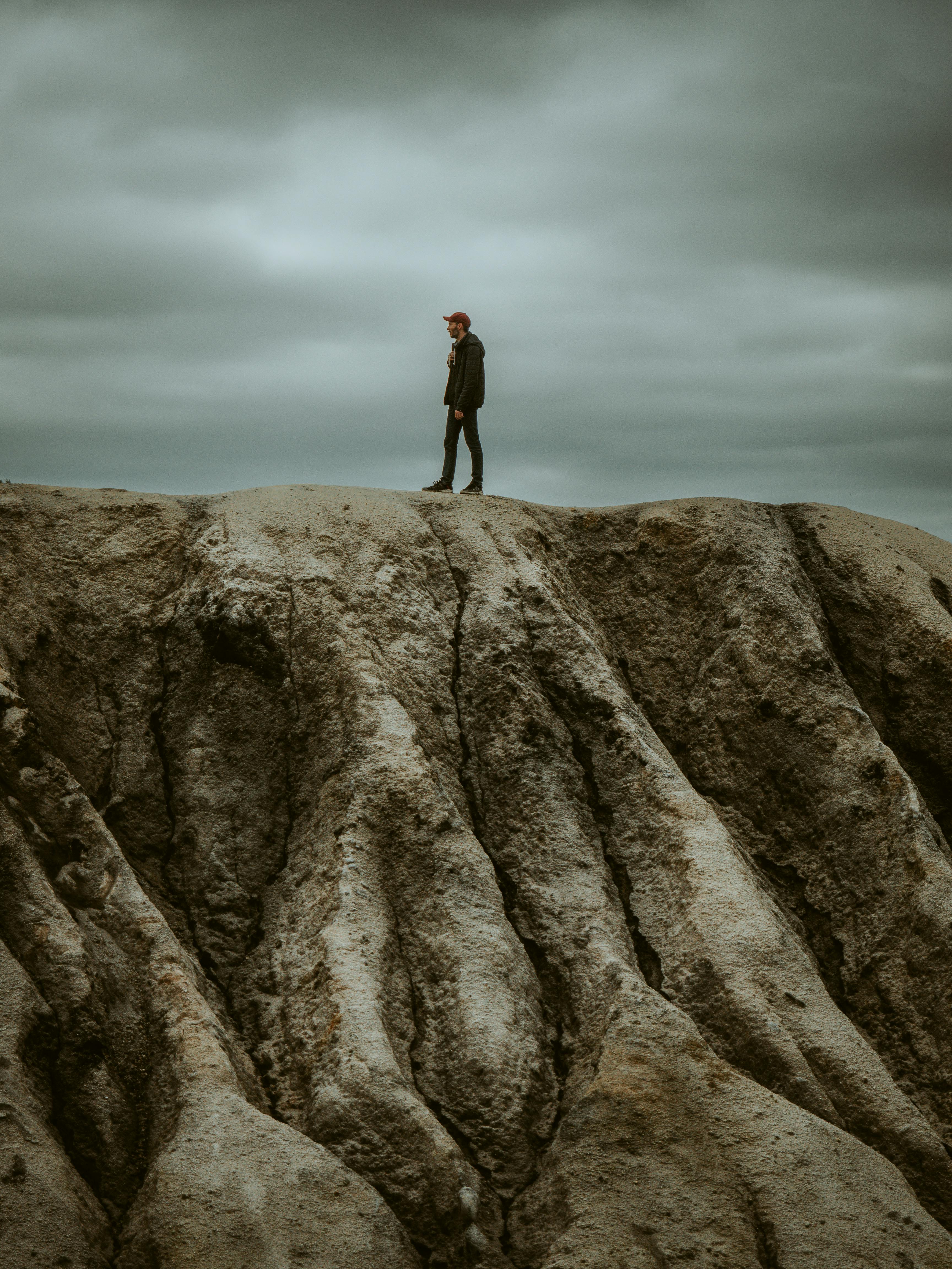 Photo of a Man Standing on a Rock · Free Stock Photo