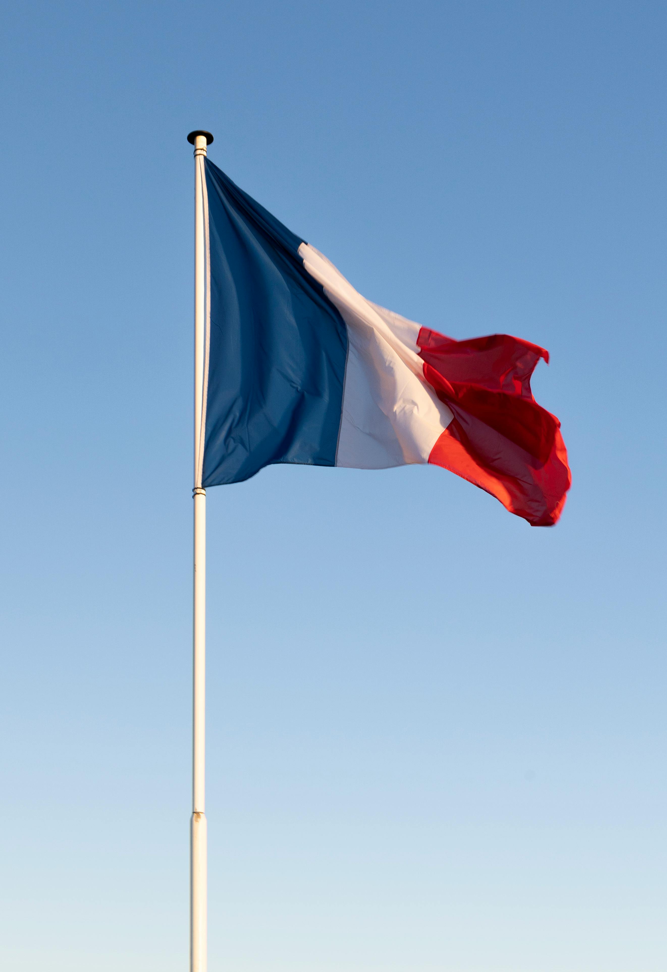 Bandera Francesa Bajo El Cielo Azul · Foto de stock gratuita
