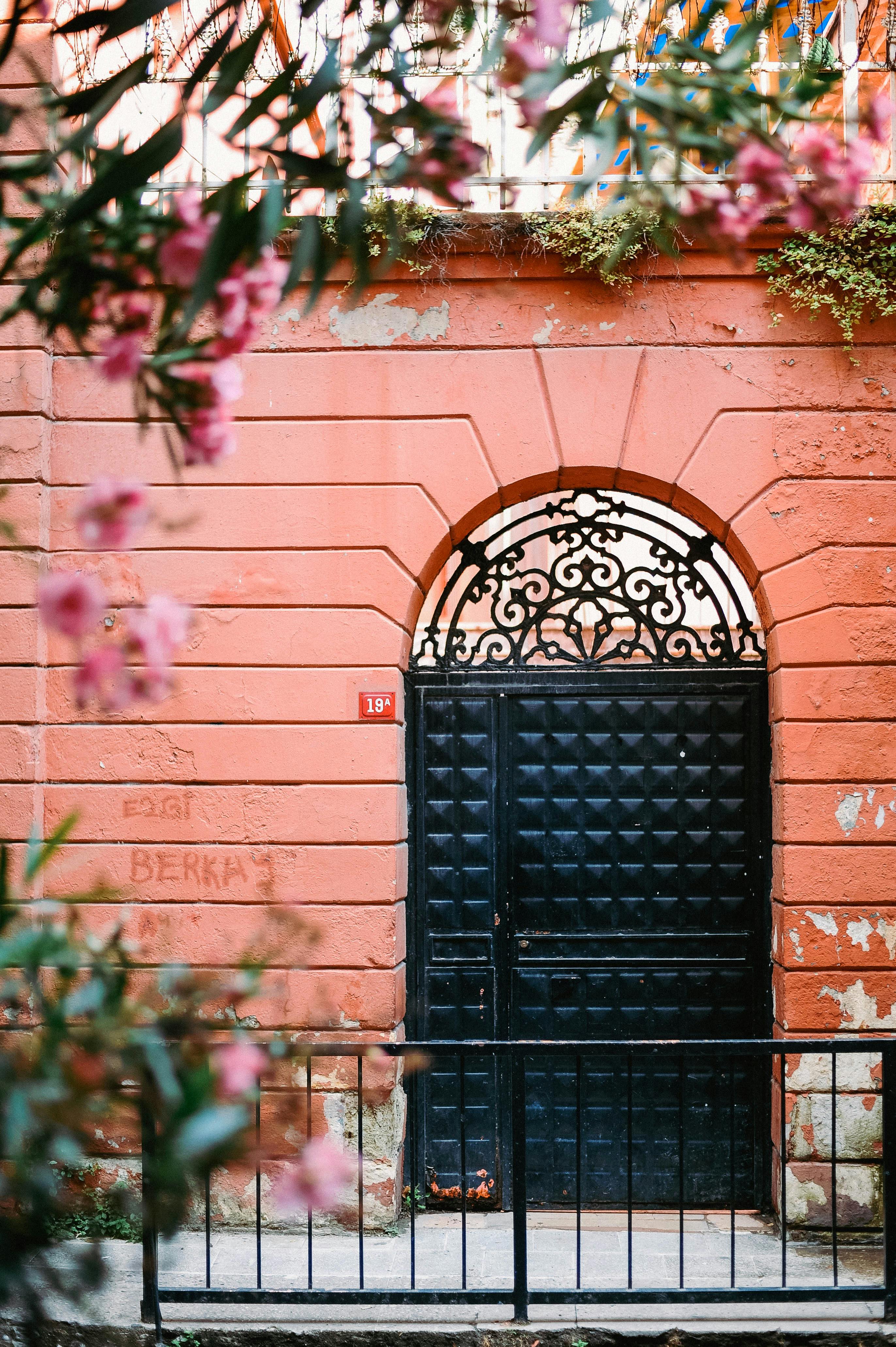 Black Metal Gate on an Orange Concrete Wall · Free Stock Photo