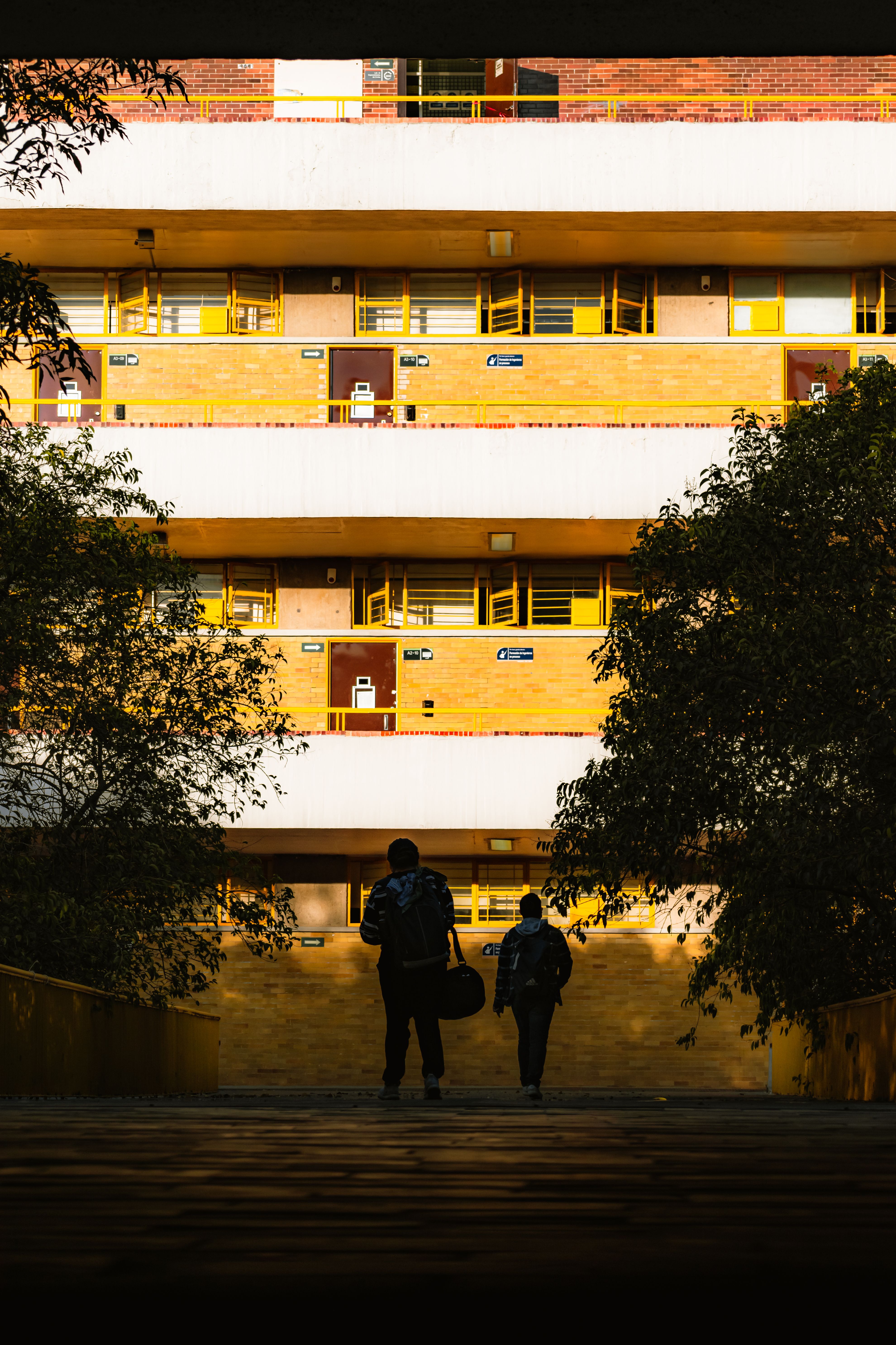 2 Person Walking Beside the Concrete Building · Free Stock Photo