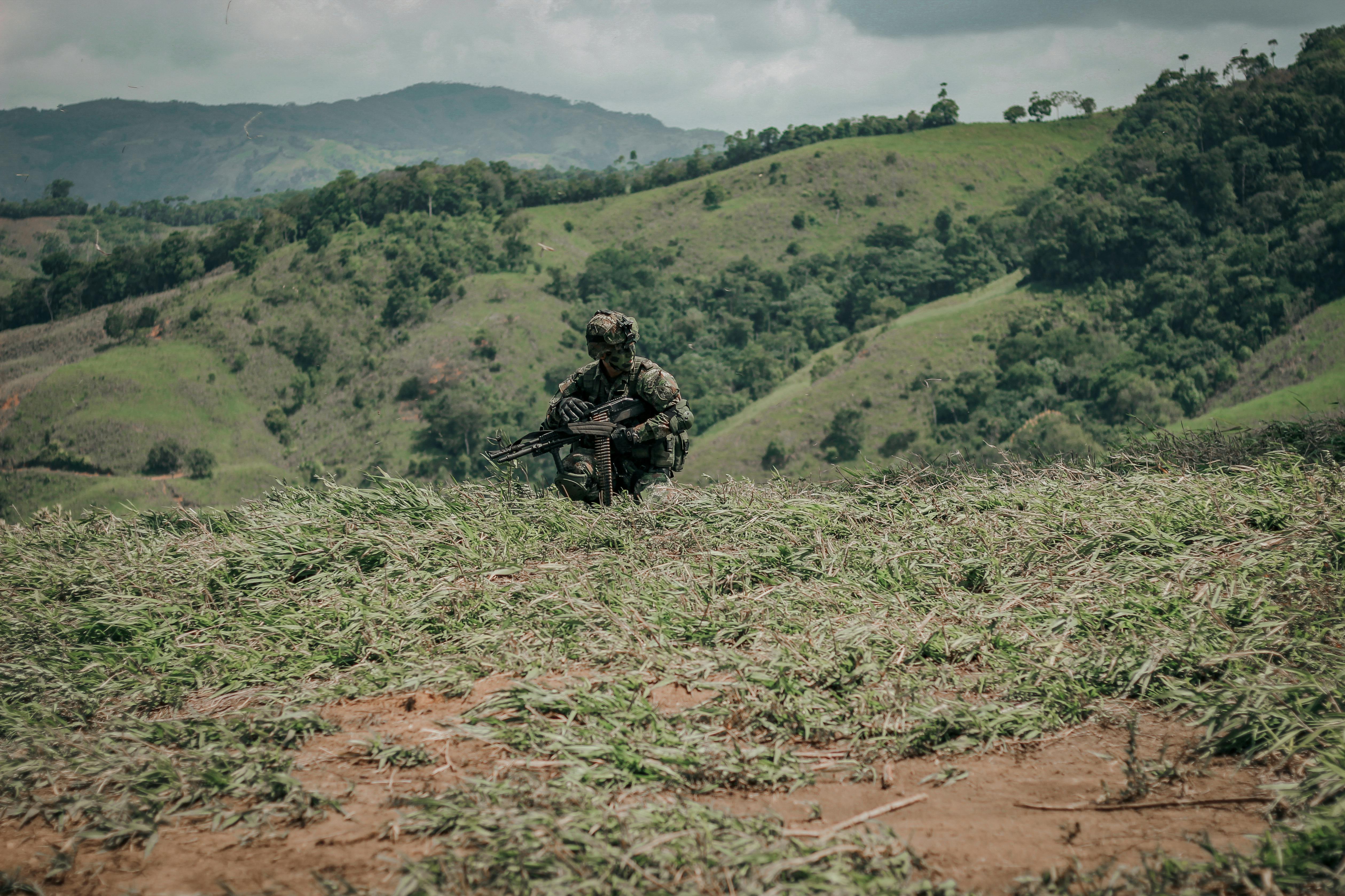 A Soldier Sitting on the Grass Field · Free Stock Photo