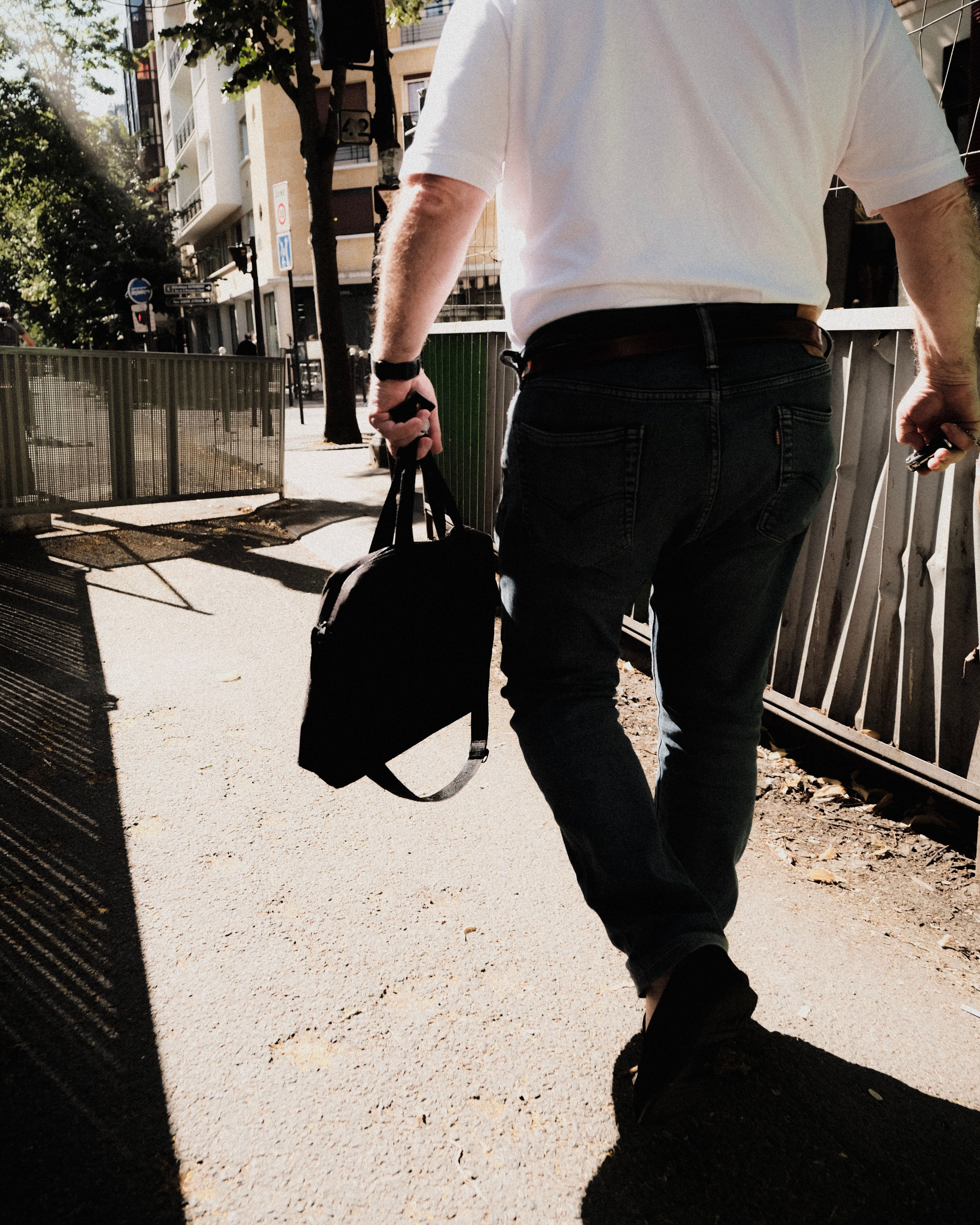 Man in White T-shirt and Black Denim Jeans Carrying Black Leather ...
